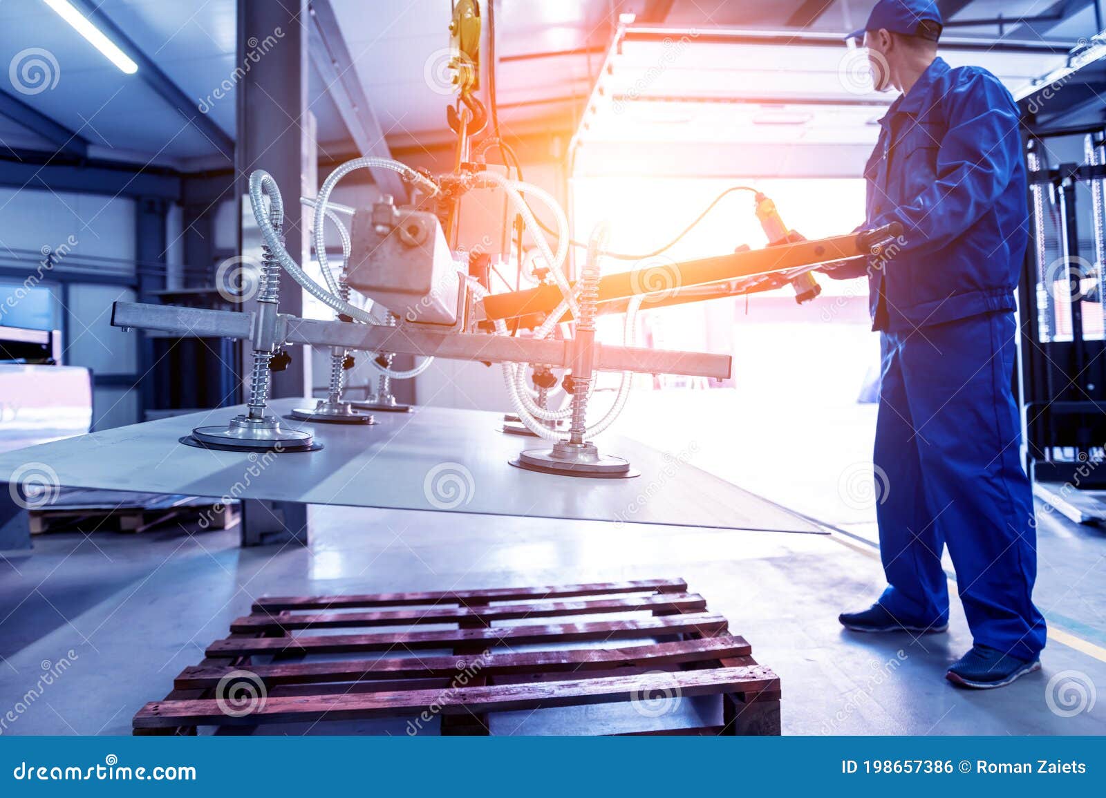Worker Uses Suction Cups for Transporting Large Sheets of Metal Stock ...