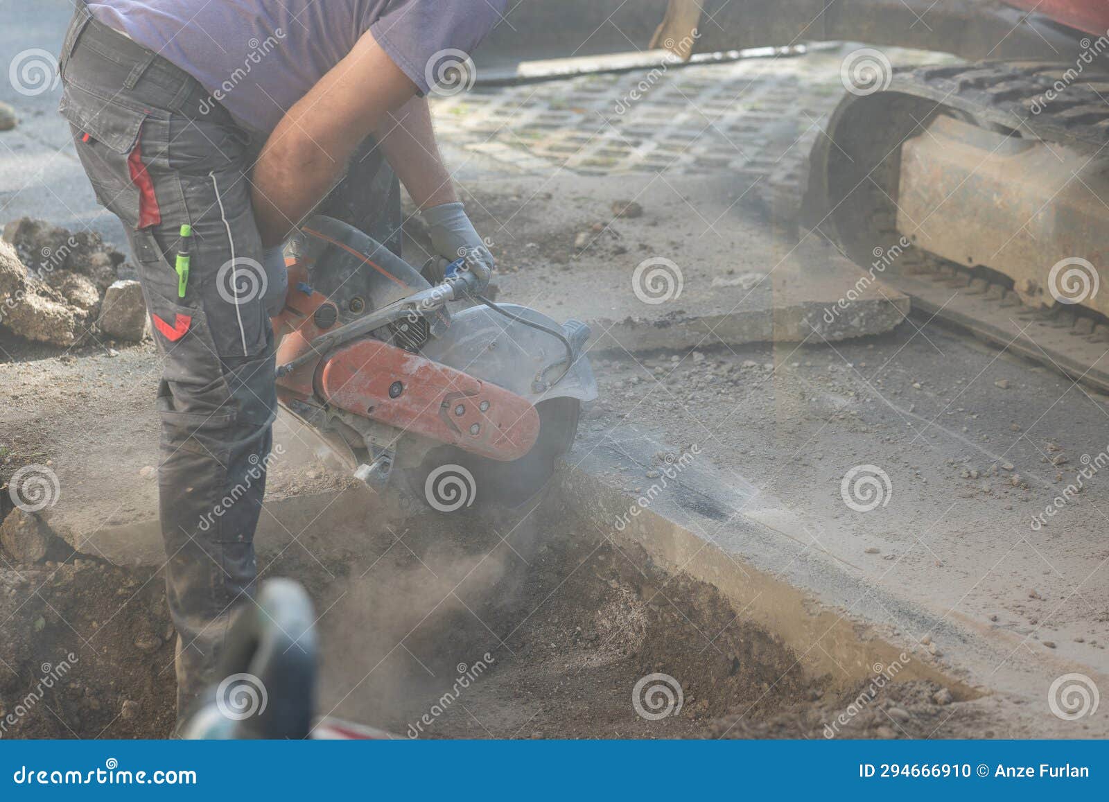 Worker Using a Motorized Asphalt Cutter or Saw with Round Blade To Cut ...
