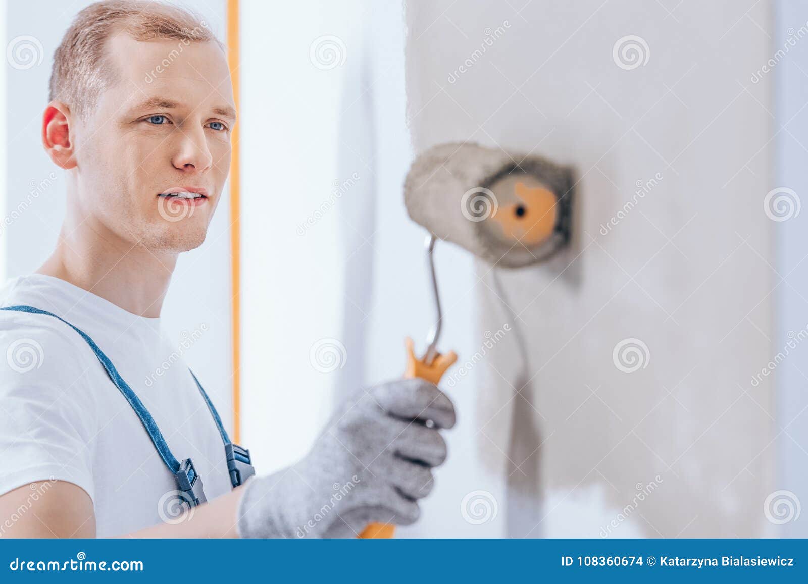 Worker using paint roller stock photo. Image of construction - 108360674