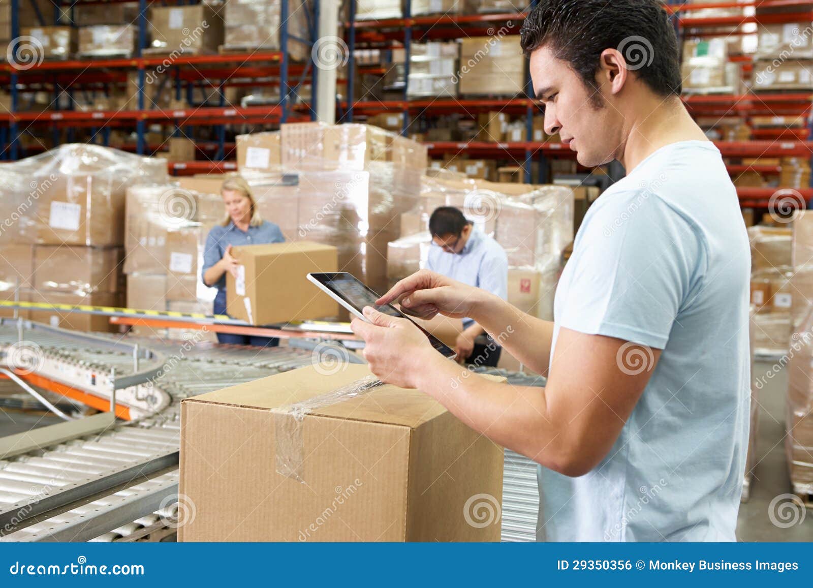Worker Using Tablet Computer in Distribution Warehouse Stock Photo ...
