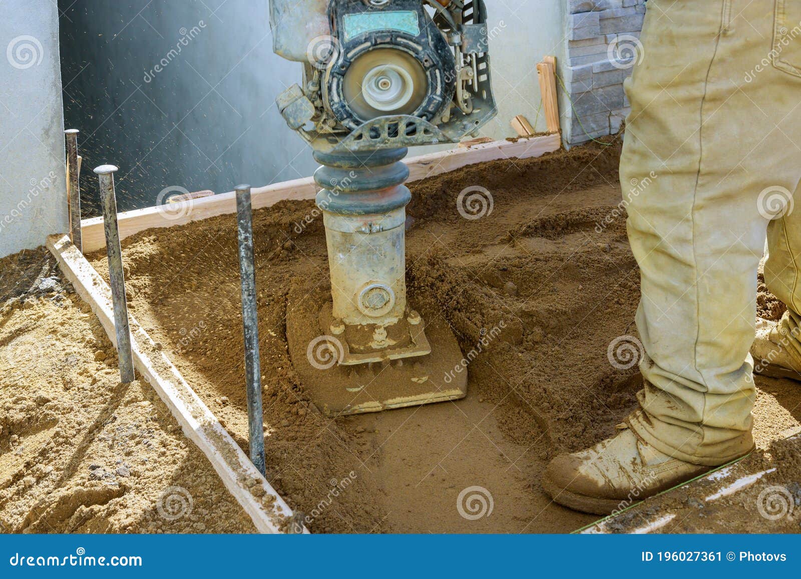 Worker With Vibratory Plate Compactor Compacting Sand At Road Or ...