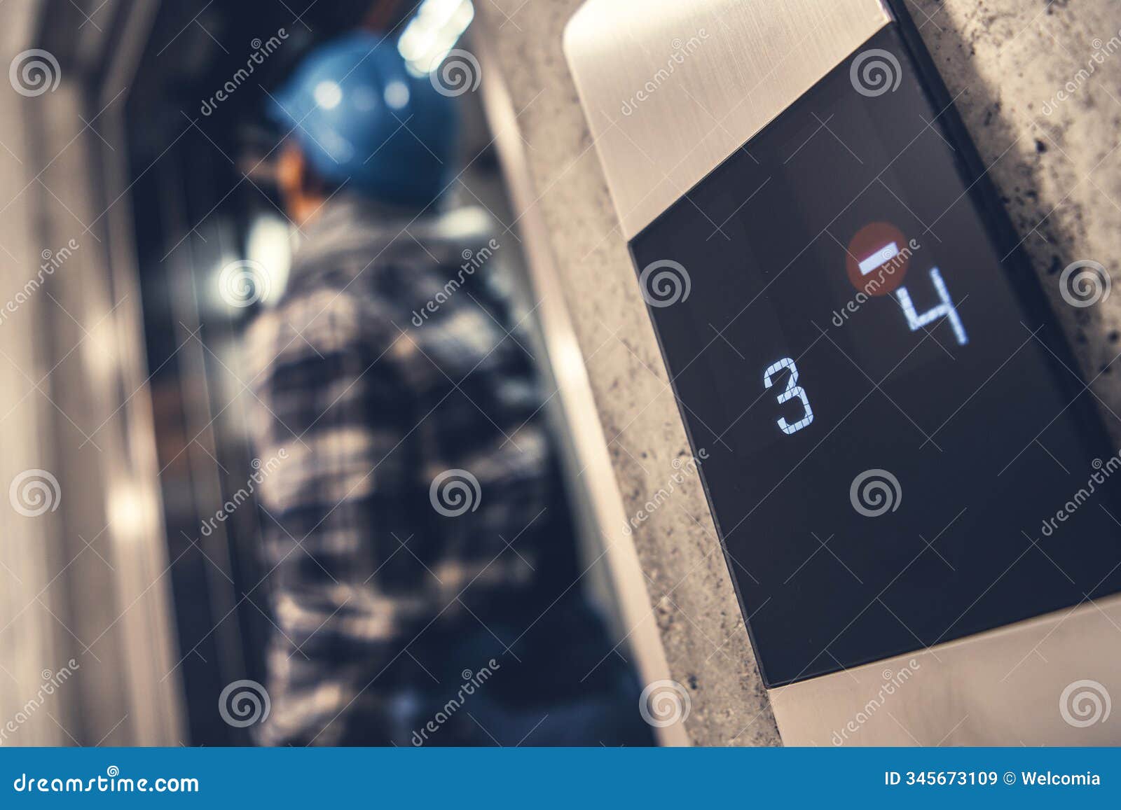 Worker Waiting for Elevator Near Display Showing Floors in a Modern ...