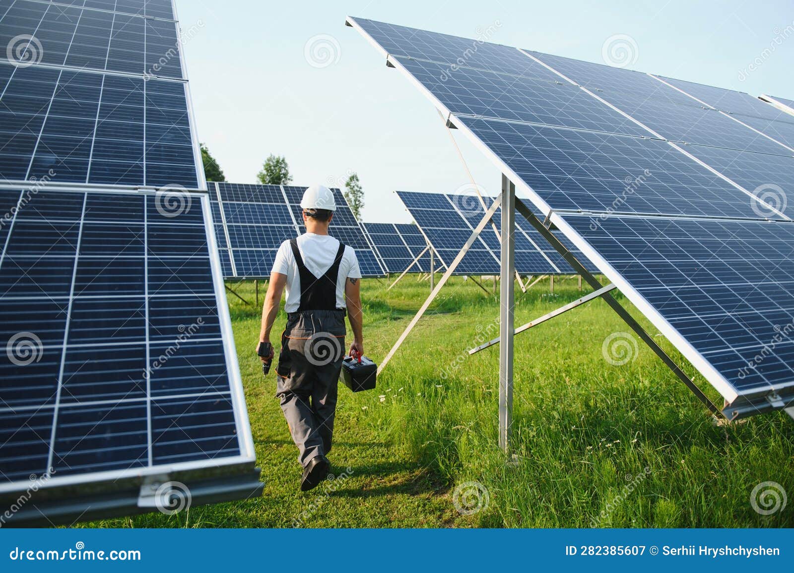A Worker Walks through a Solar Panel Farm Stock Image - Image of ...