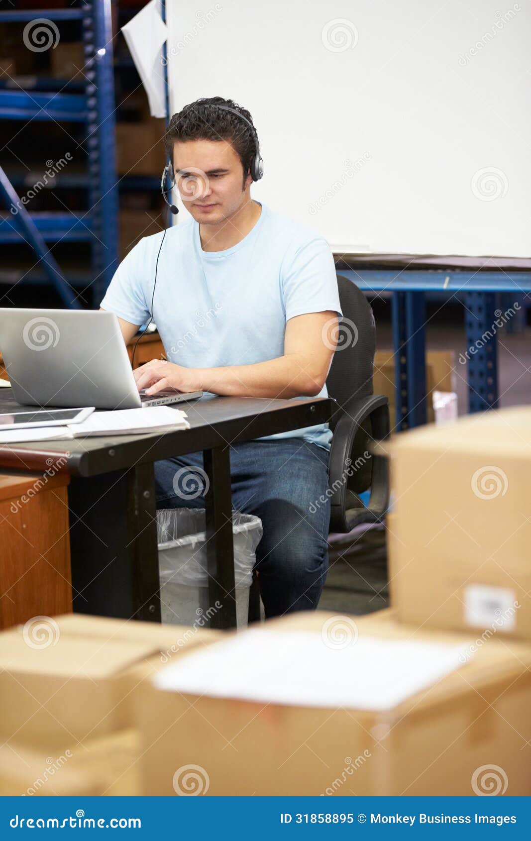 Worker in Warehouse Wearing Headset and Using Laptop Stock Image ...