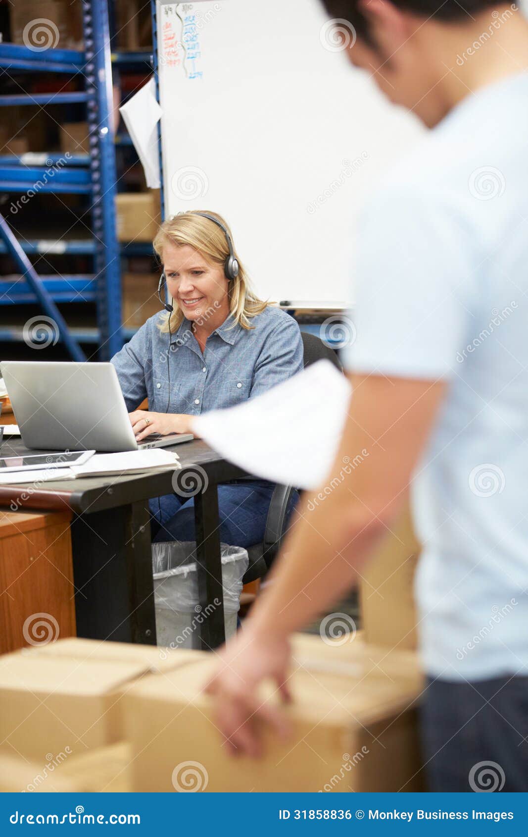 Worker in Warehouse Wearing Headset and Using Laptop Stock Photo ...