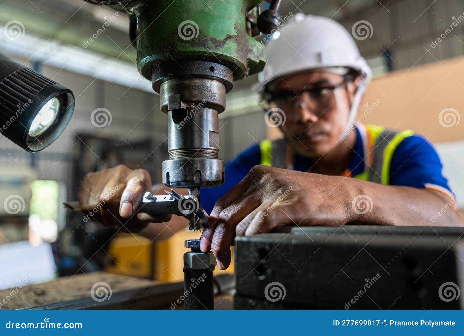 A Worker Wearing Safety Glasses Working on a Lathe Machine. Selective ...