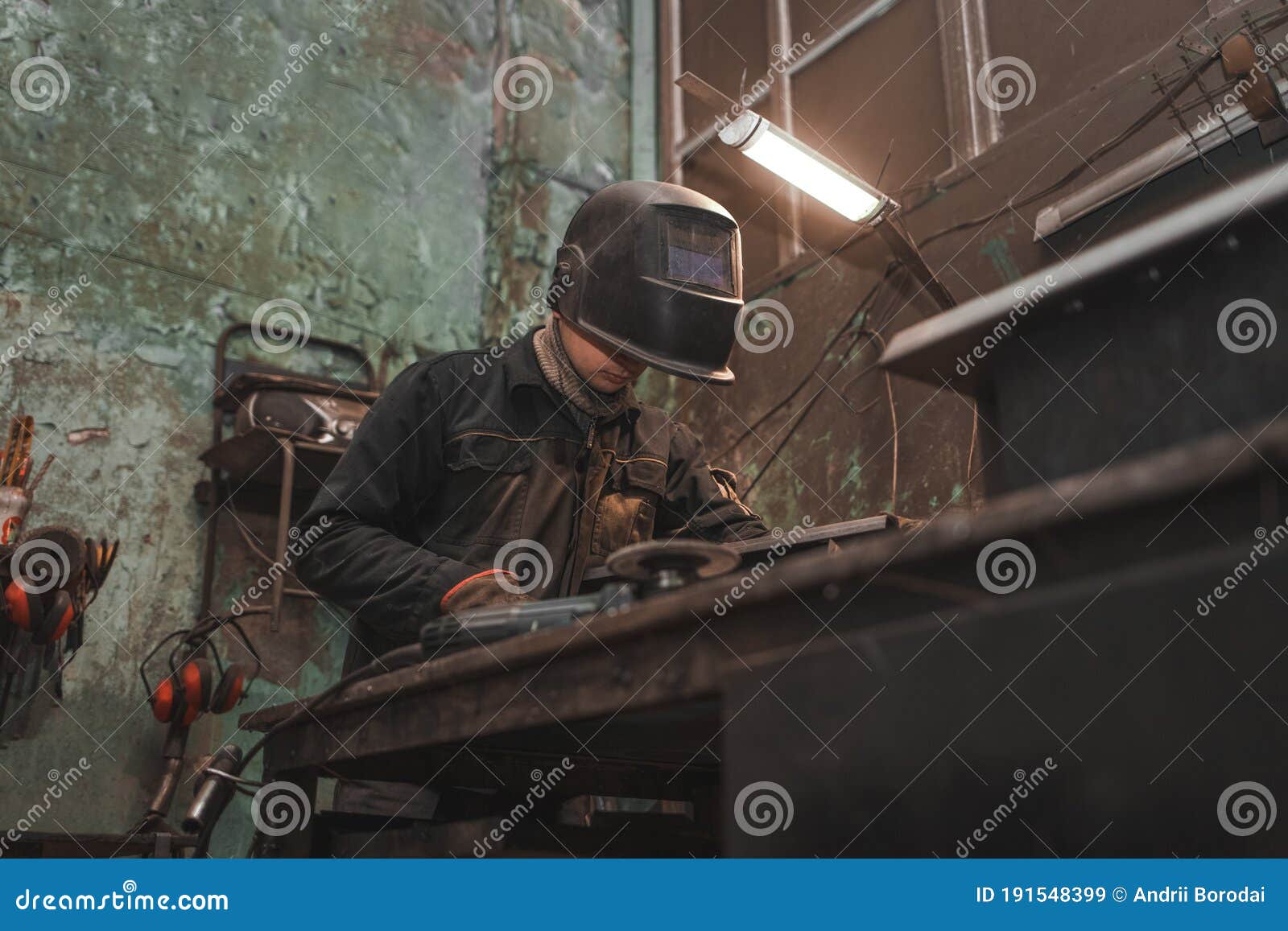 Worker in a Welder Mask Works in a Workshop for Welding Iron. Man Makes ...