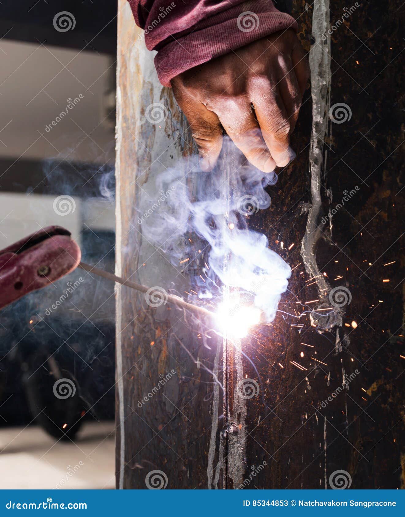 Worker Welding Steel with Spark Lighting and Smoke at Construction Site ...