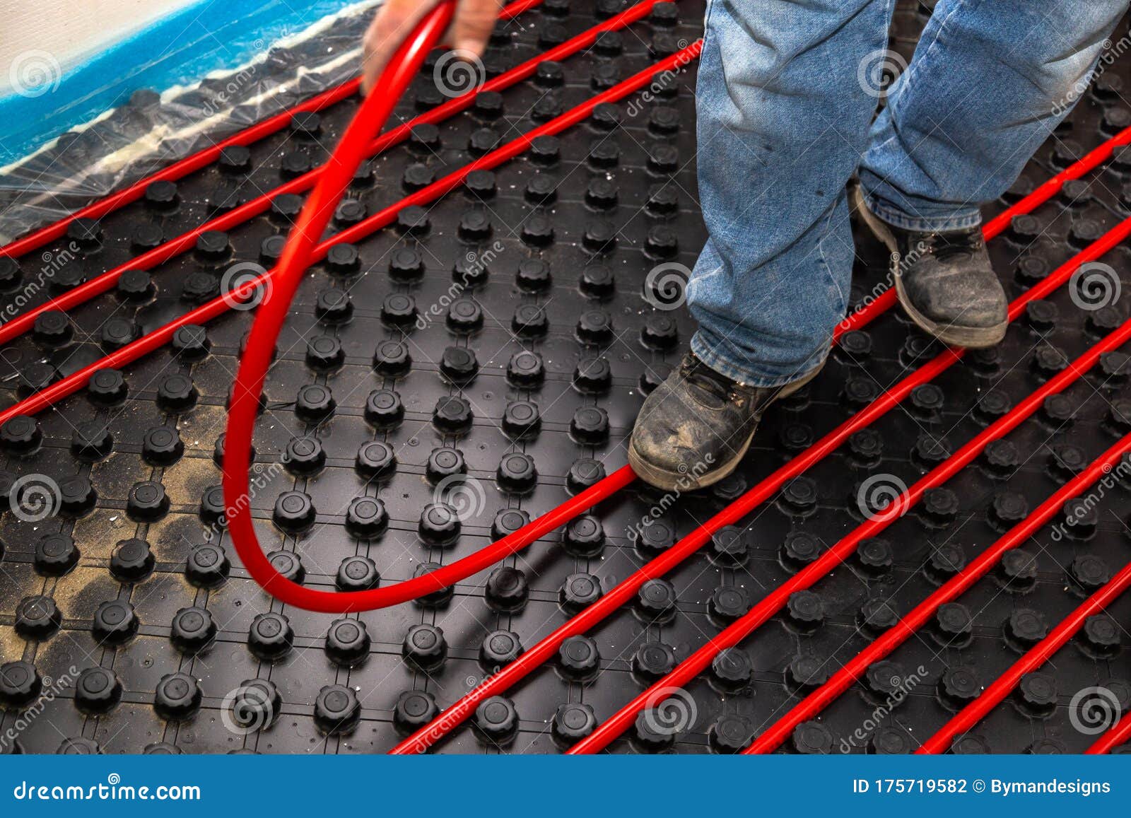 Worker Who Instal Red Tubes of Radiant Underfloor Heating Installation ...
