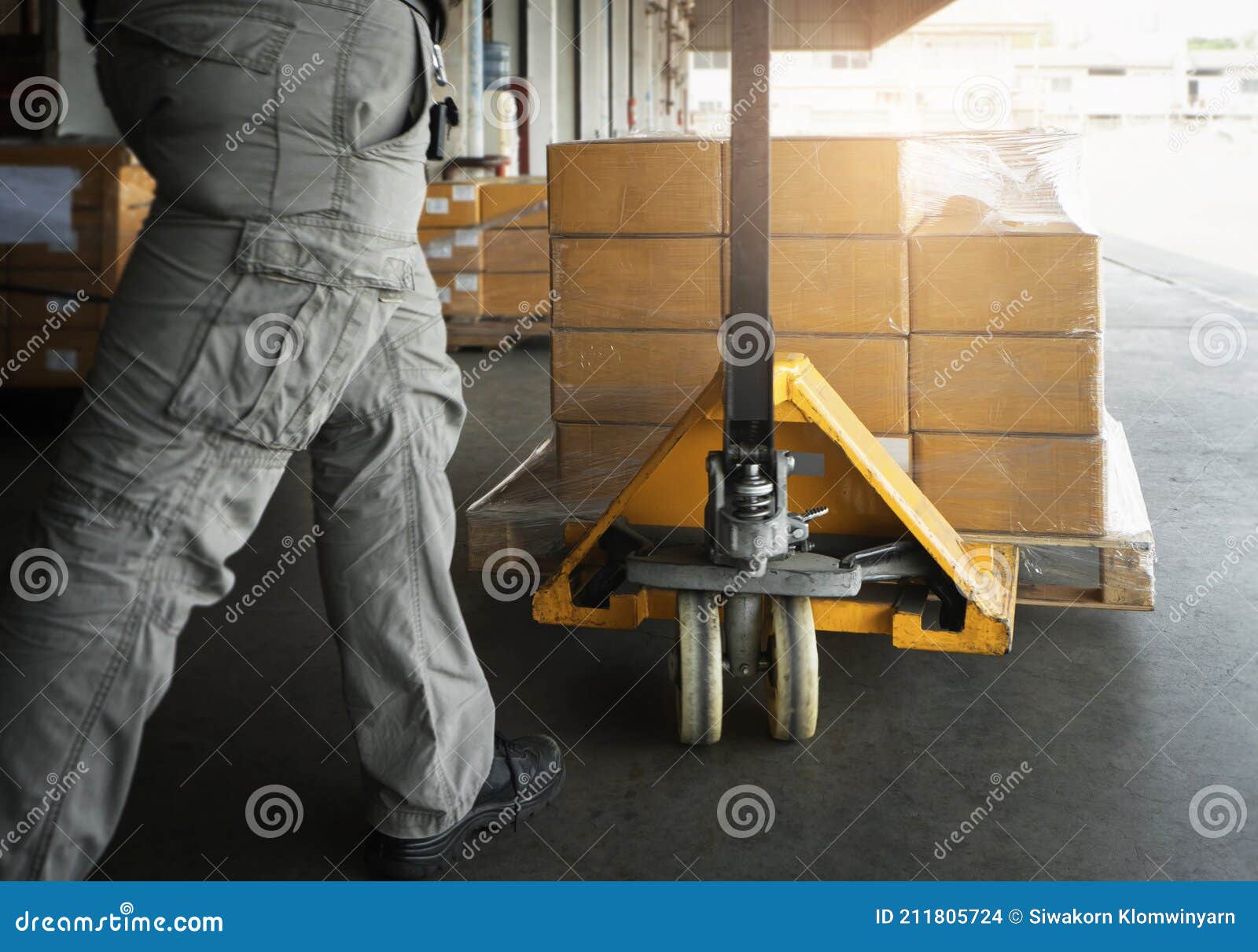 Worker Working with Hand Pallet Jack Unloading Cargo Boxes at Storage ...