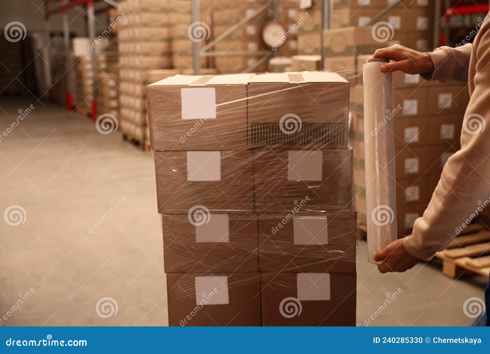 Worker Wrapping Boxes in Stretch Film at Warehouse, Closeup Stock Photo ...