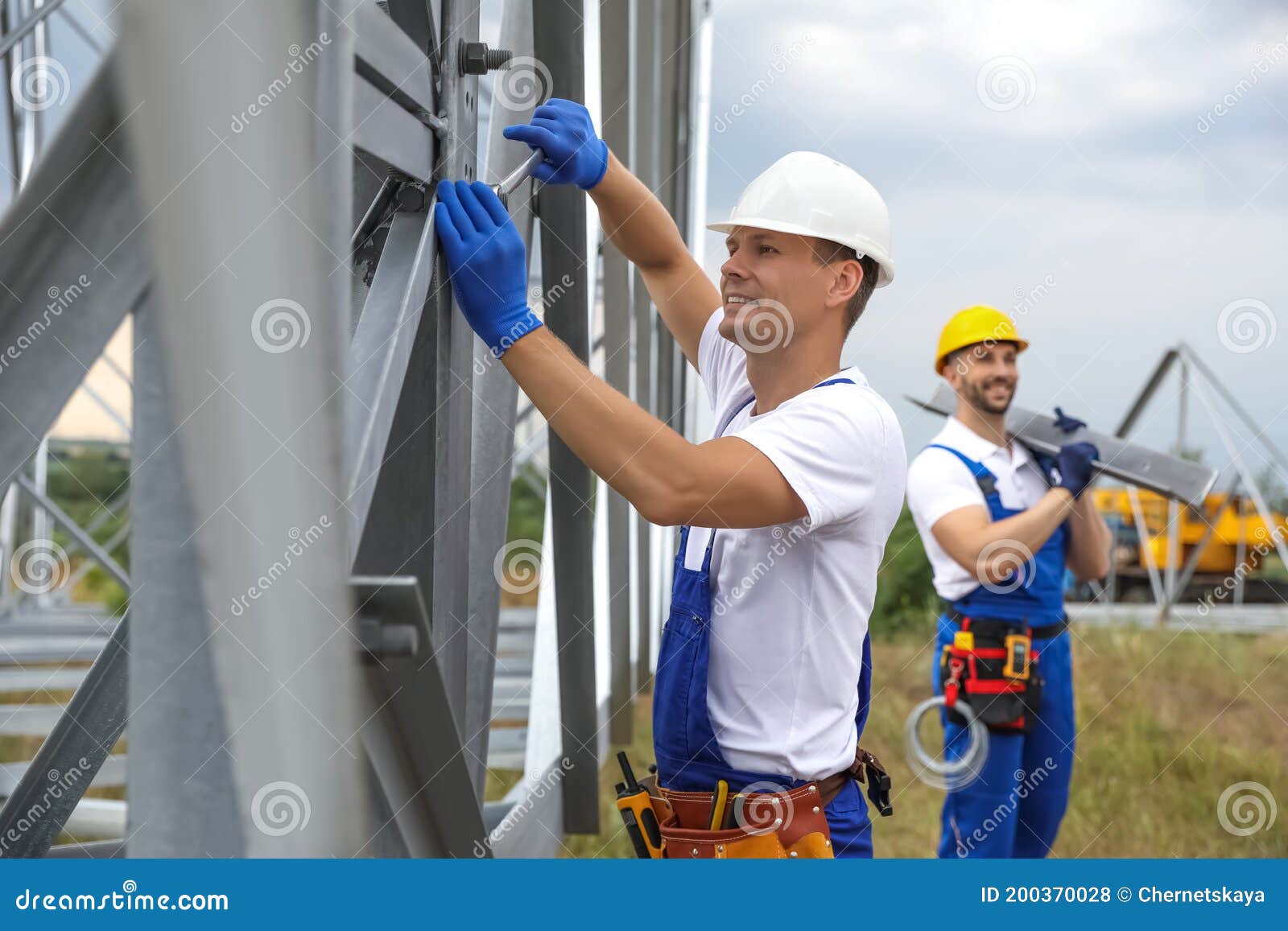 Workers Building High Voltage Tower Construction Outdoors. Installation ...