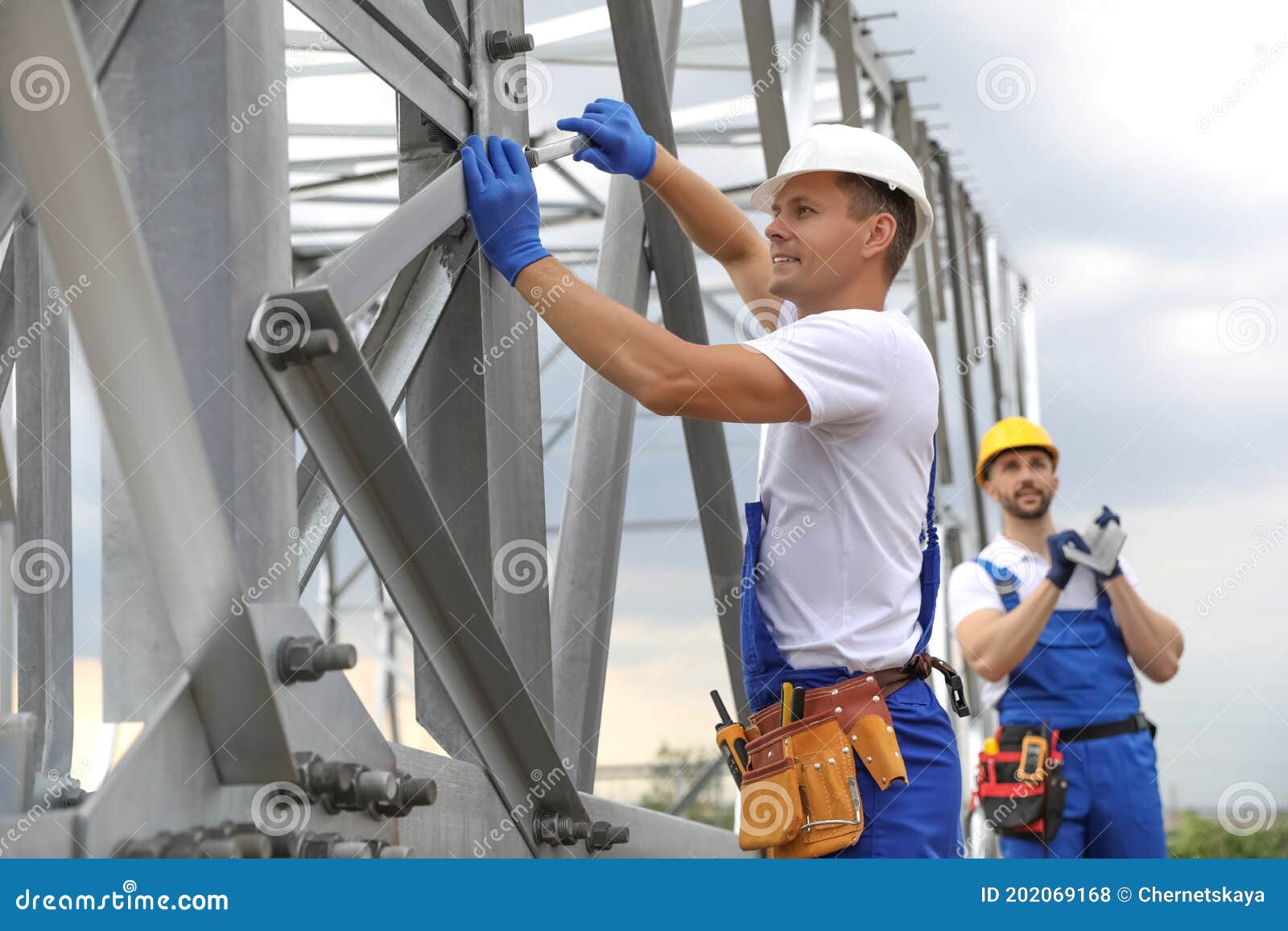 Workers Building High Voltage Tower Construction Outdoors. Installation ...