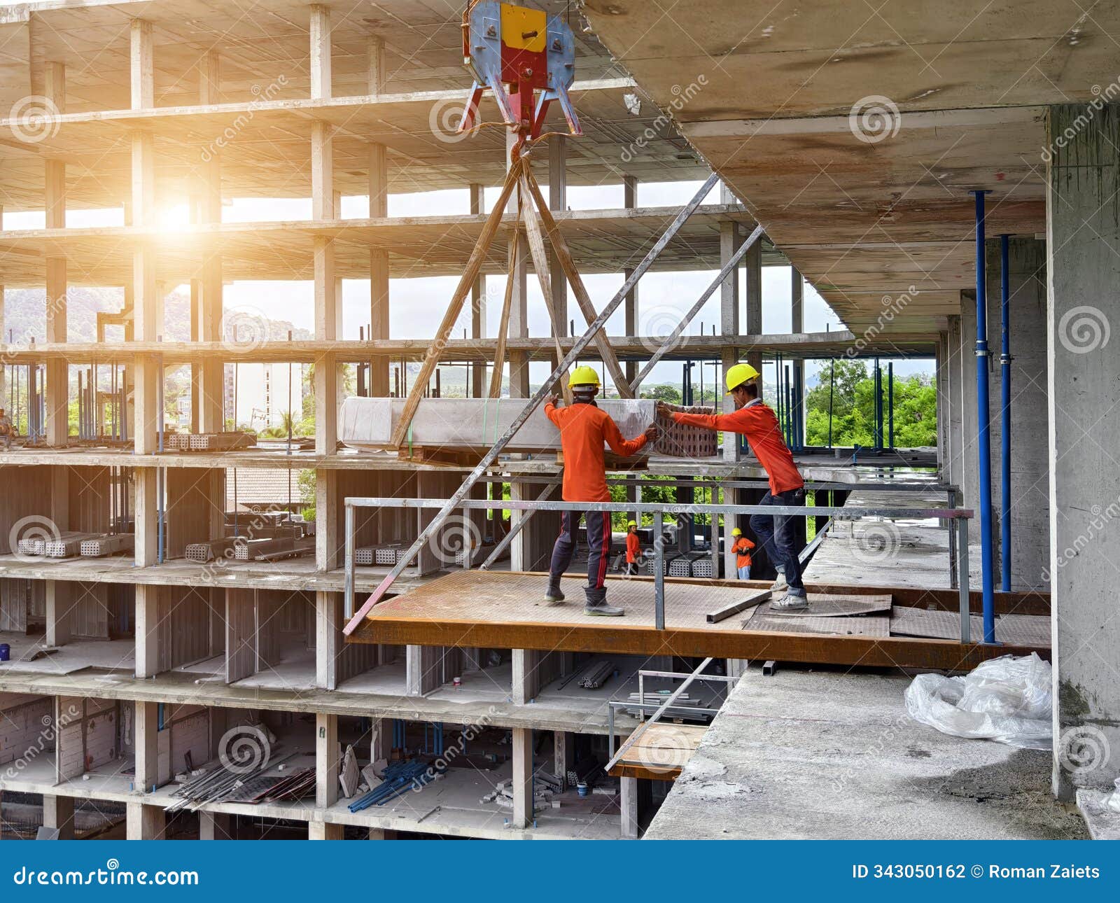 Workers at a Building Under Construction Take Slabs from a Crane Stock ...