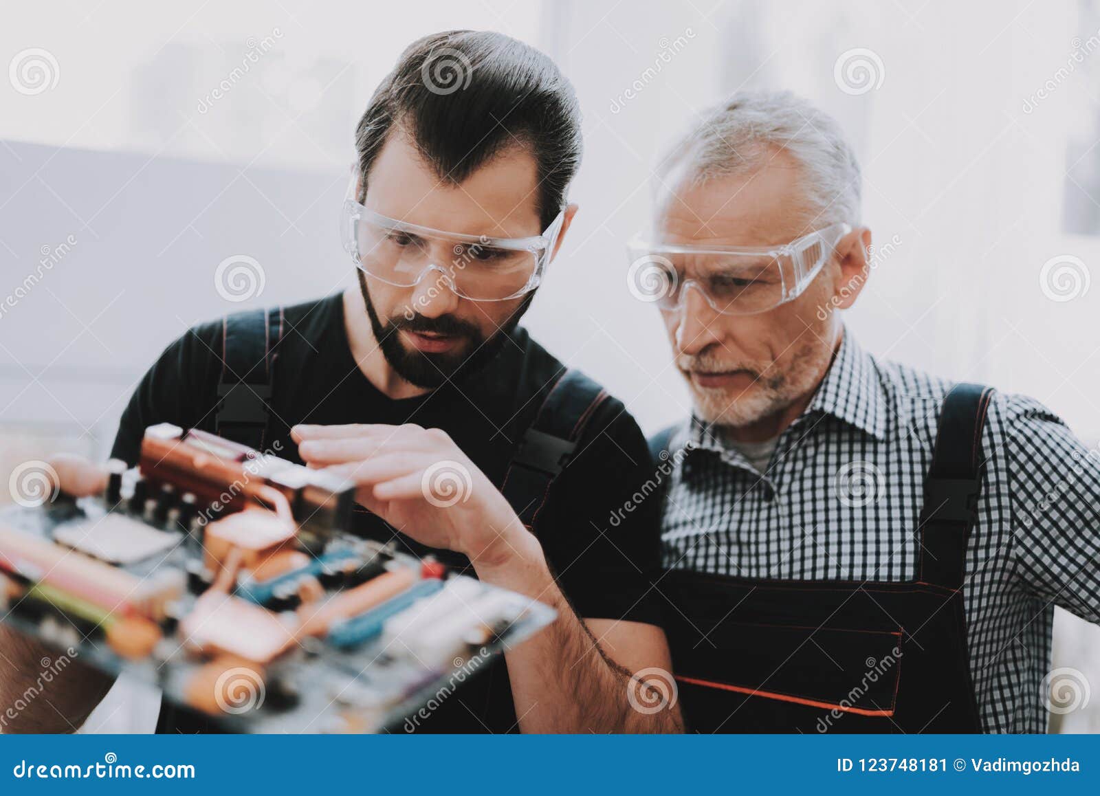 Workers Checking Device in Hands in Repair Shop. Stock Image - Image of ...