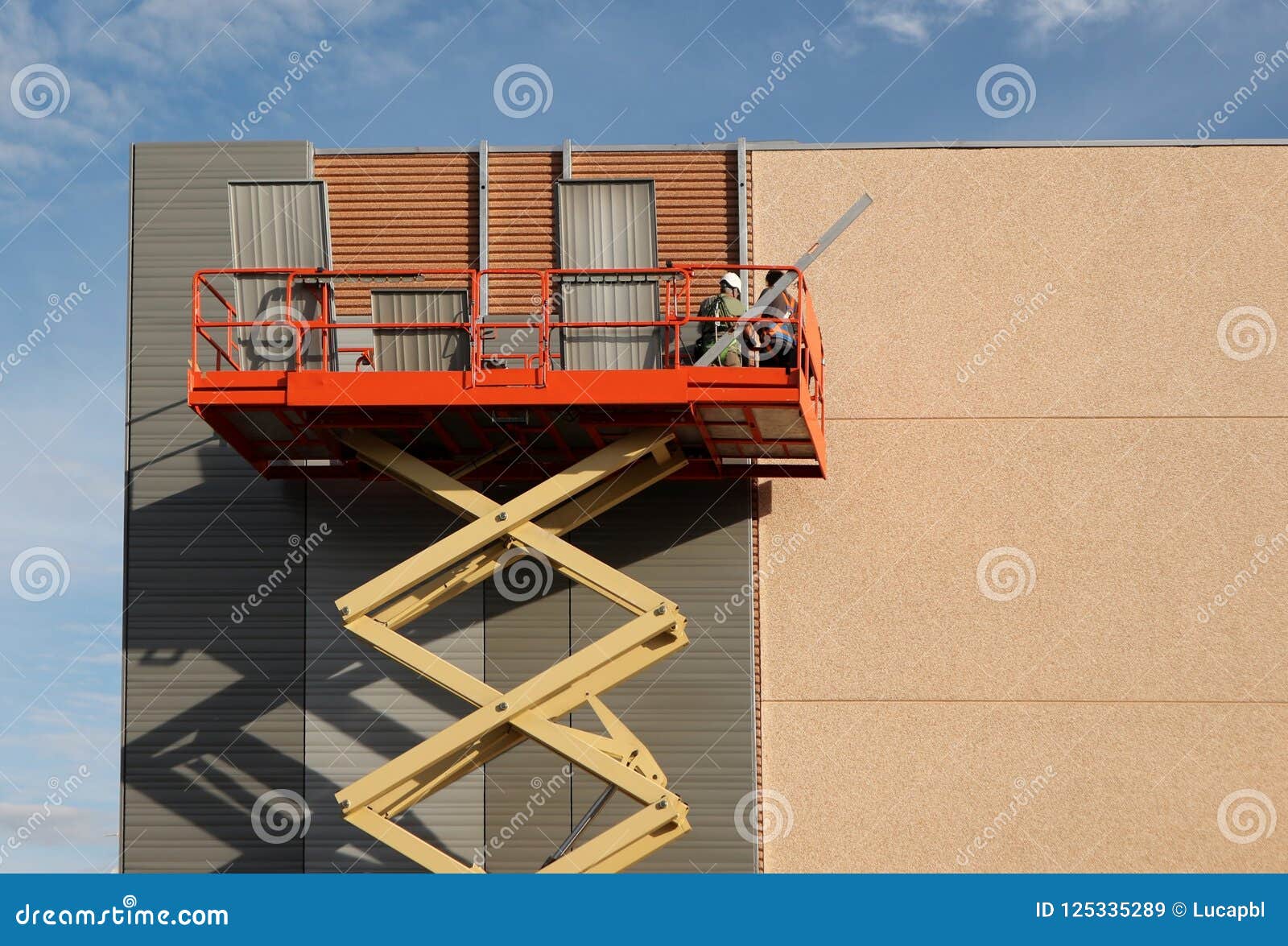 Workers on a Cherry Picker Refurbish the Facade of a Building by ...