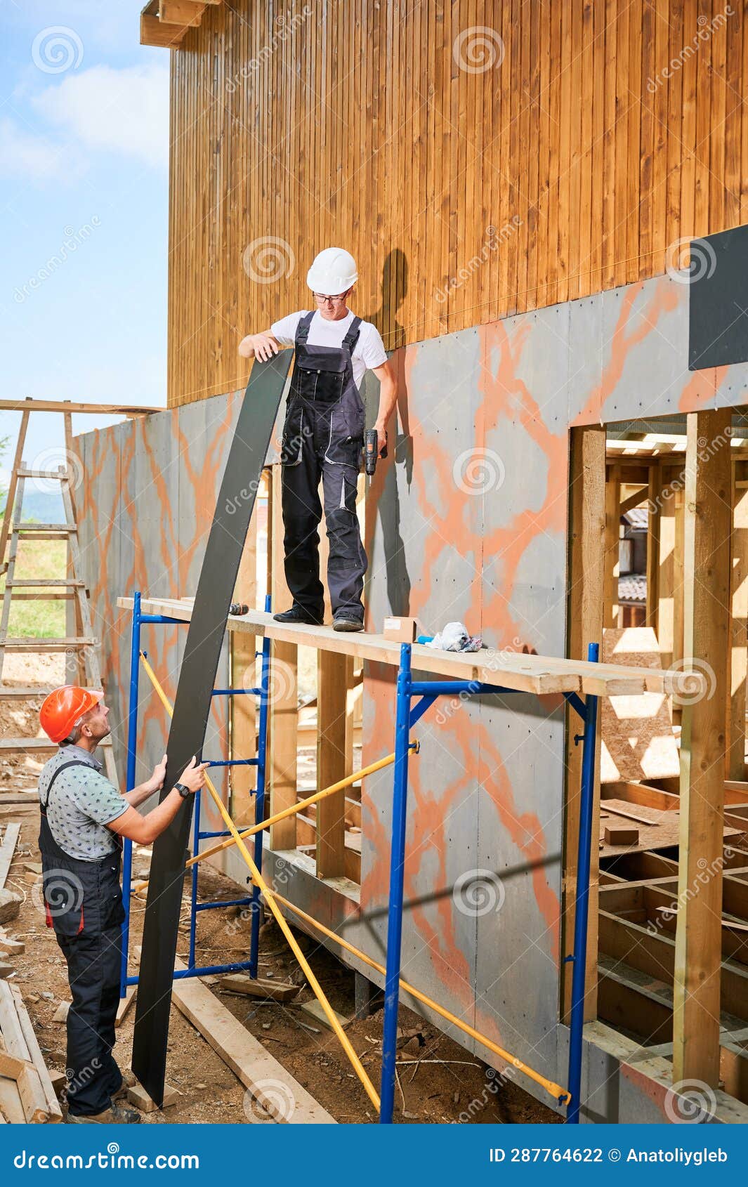 Workers Cladding Facade of House with Cement Particle Boards while ...