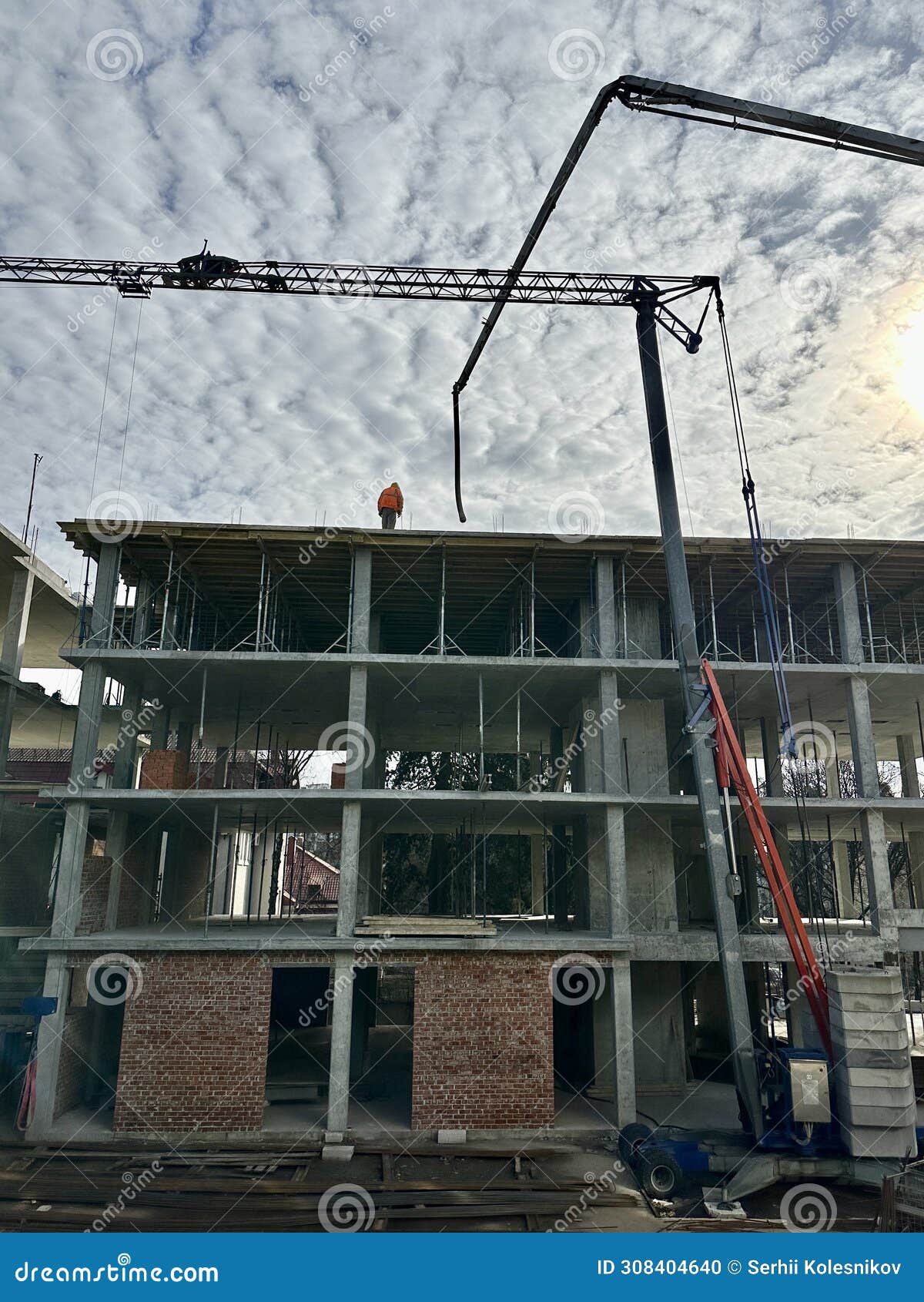 Workers at a Construction Site Against the Backdrop of the Construction ...