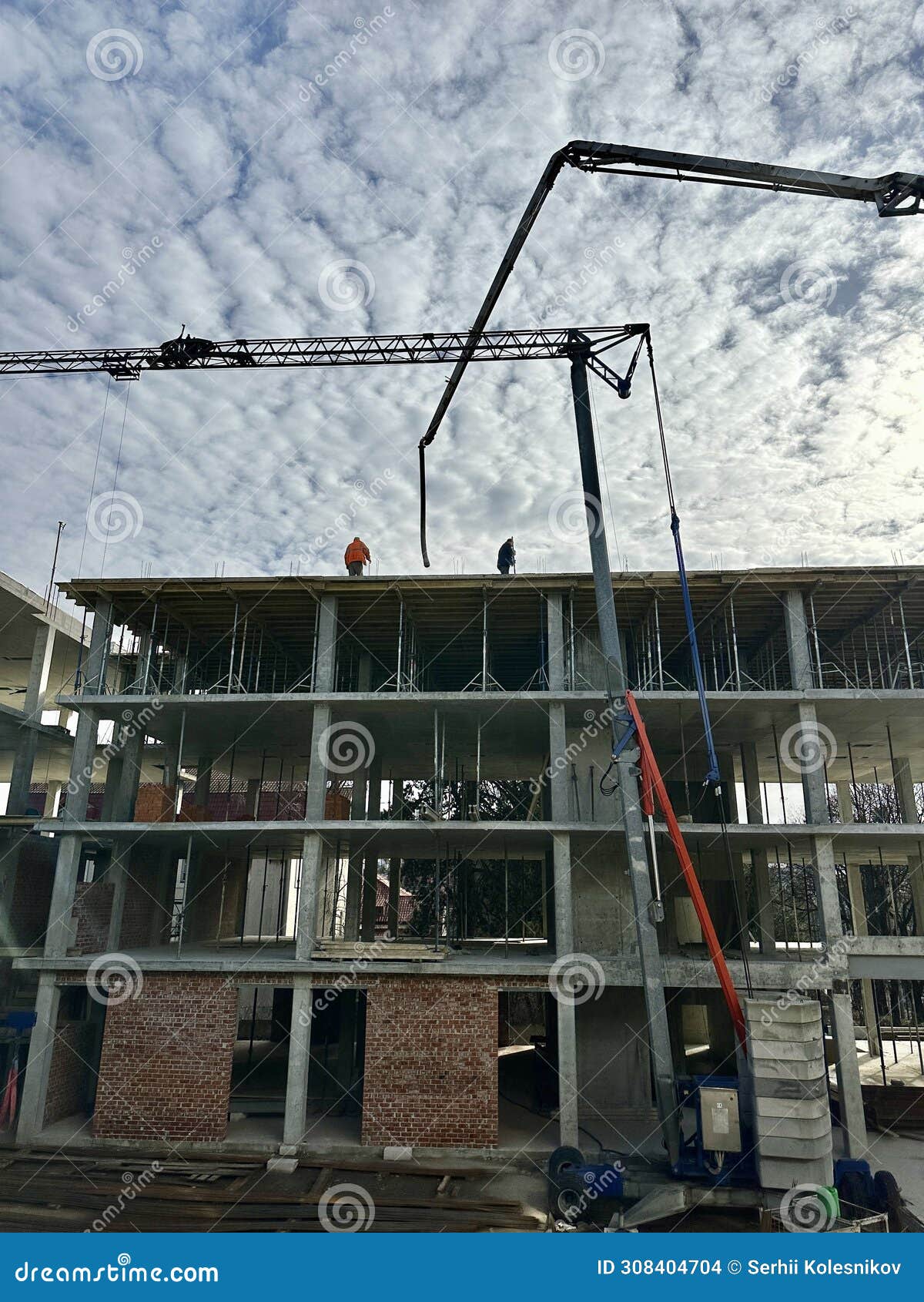 Workers at a Construction Site Against the Backdrop of the Construction ...