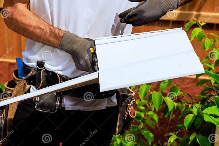Workers Cut Plastic Vinyl Siding To Size Using Scissors Prior To a ...