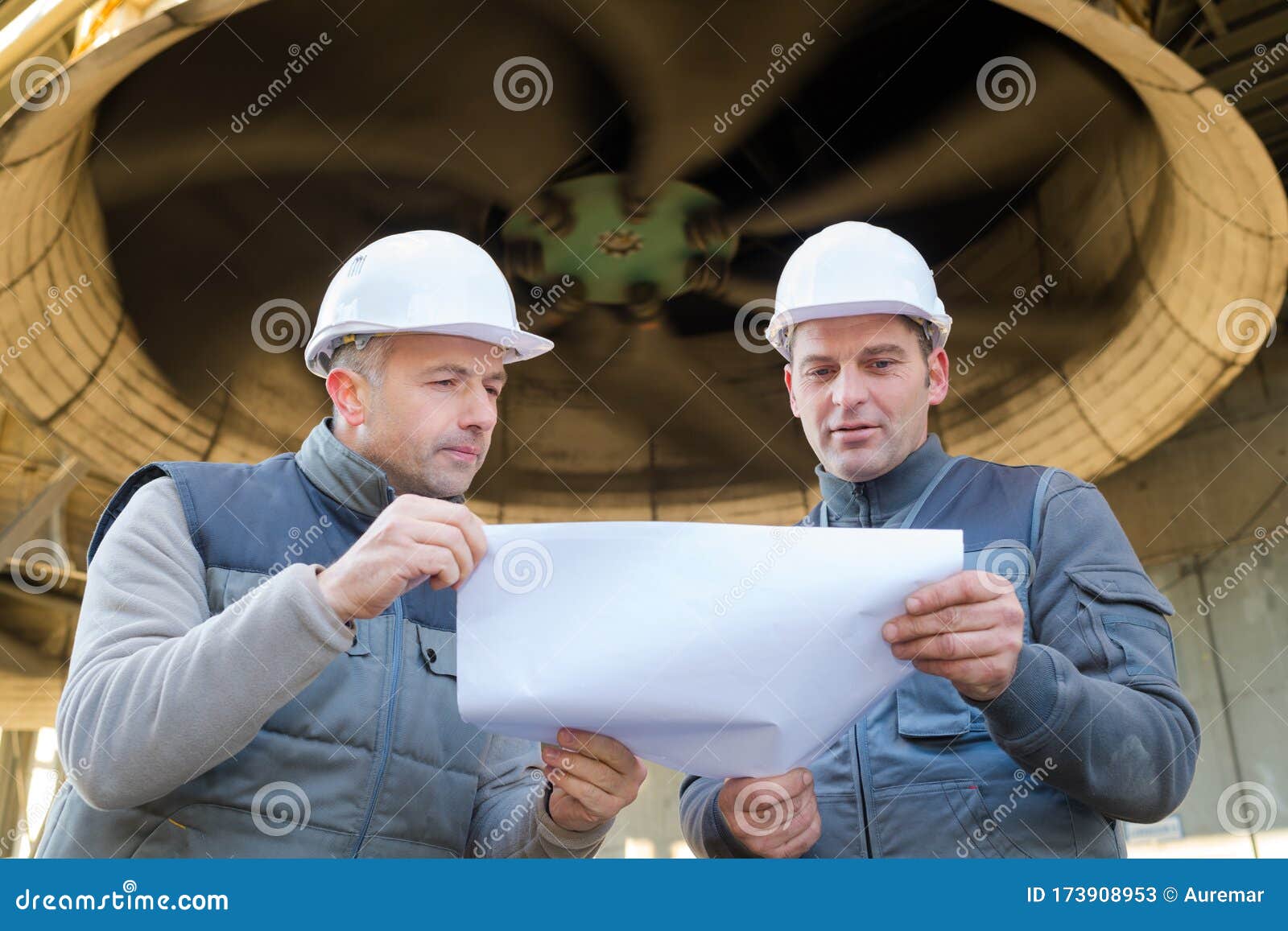 Workers Discussing Paperwork on Construction Site Stock Image - Image ...