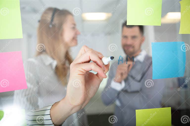 Workers Discussing Strategy and Writing Key Points on Window Stock ...