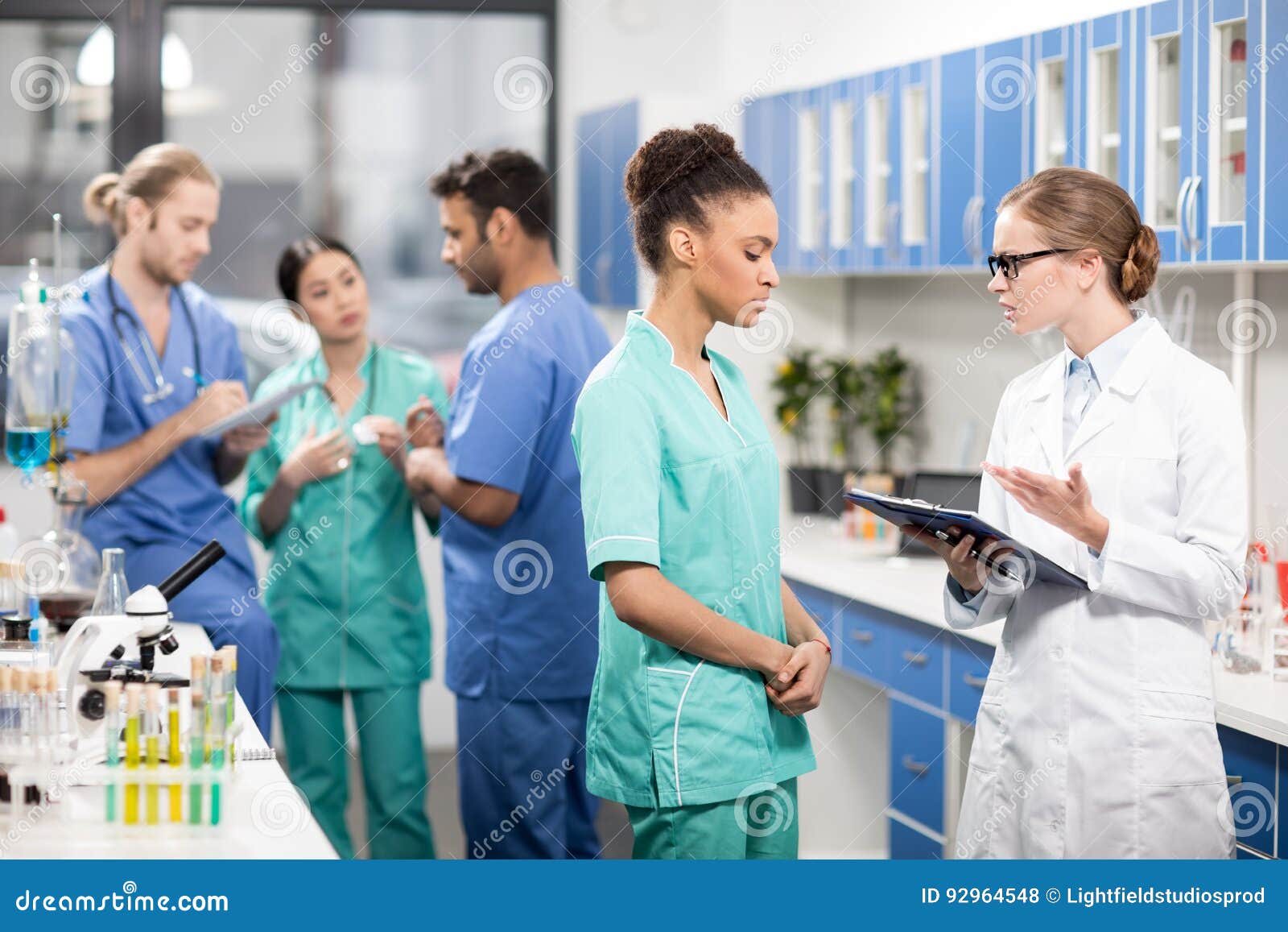Workers Discussing Work with Colleagues Behind in Laboratory Stock ...