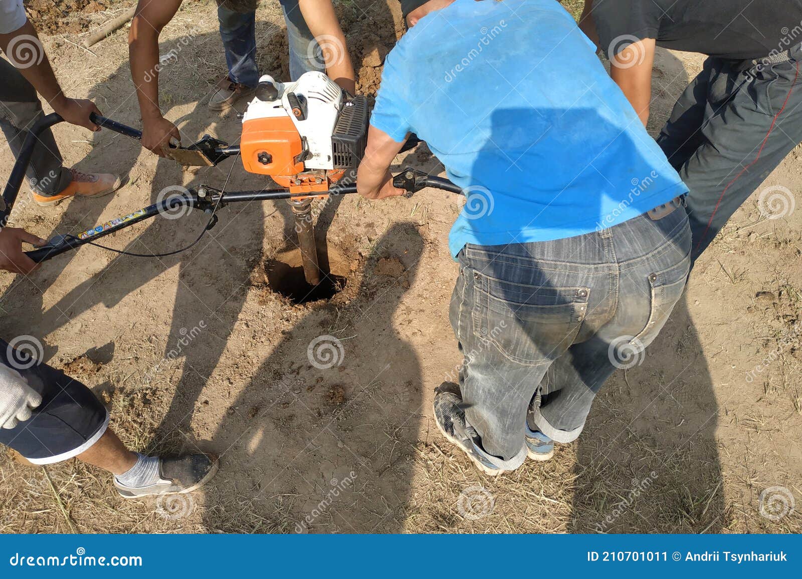 Workers are Drilling Pits for Poles, Starting Work with a Hand Drill ...