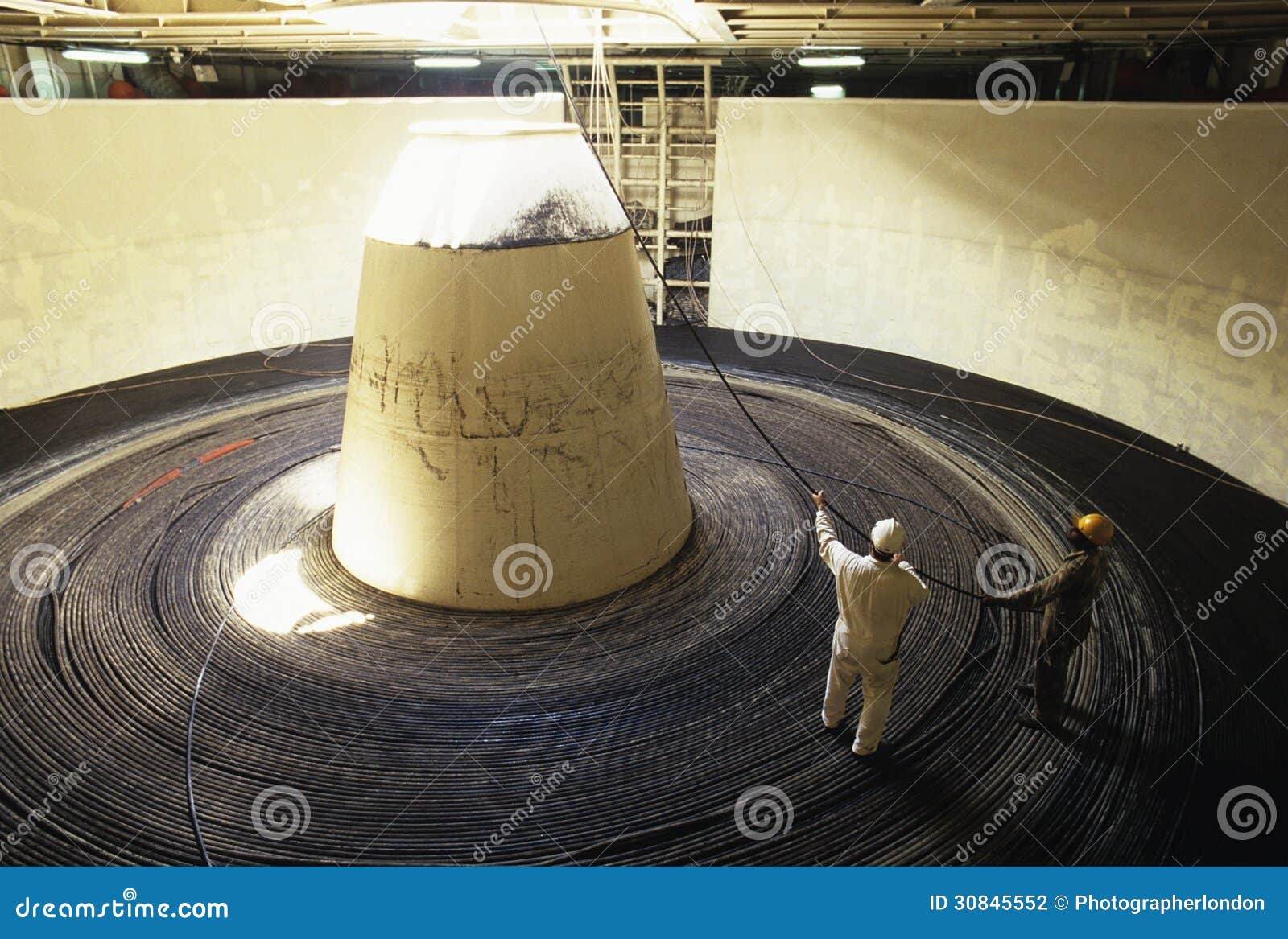 Workers Feeding Steel Cable through Hole in Ceiling Stock Photo - Image ...