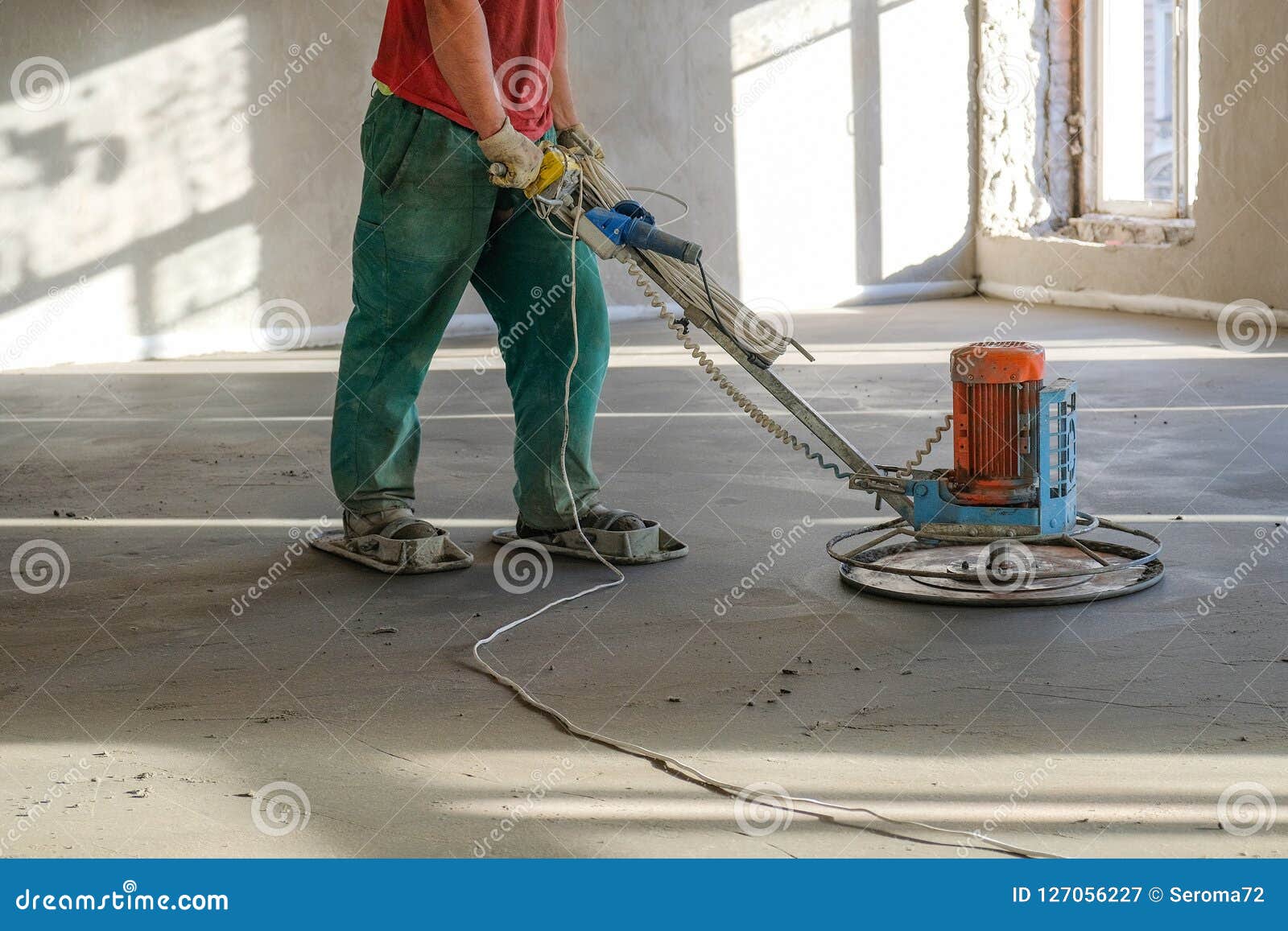 The Workers Grind the Concrete Floor at the Construction Site Stock ...