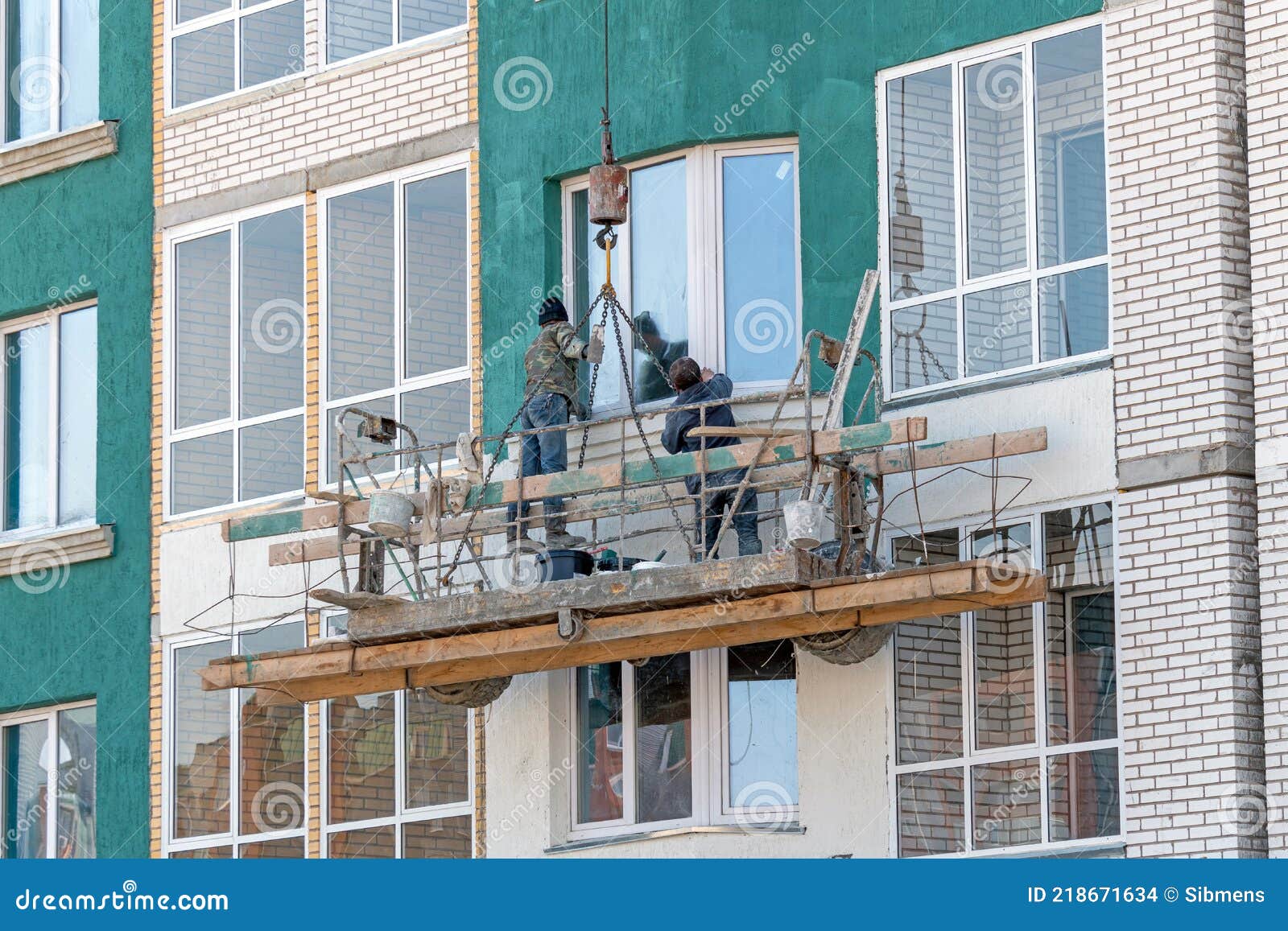 Workers in a Hanging Cradle Repair the Facade of a Building Stock Photo ...