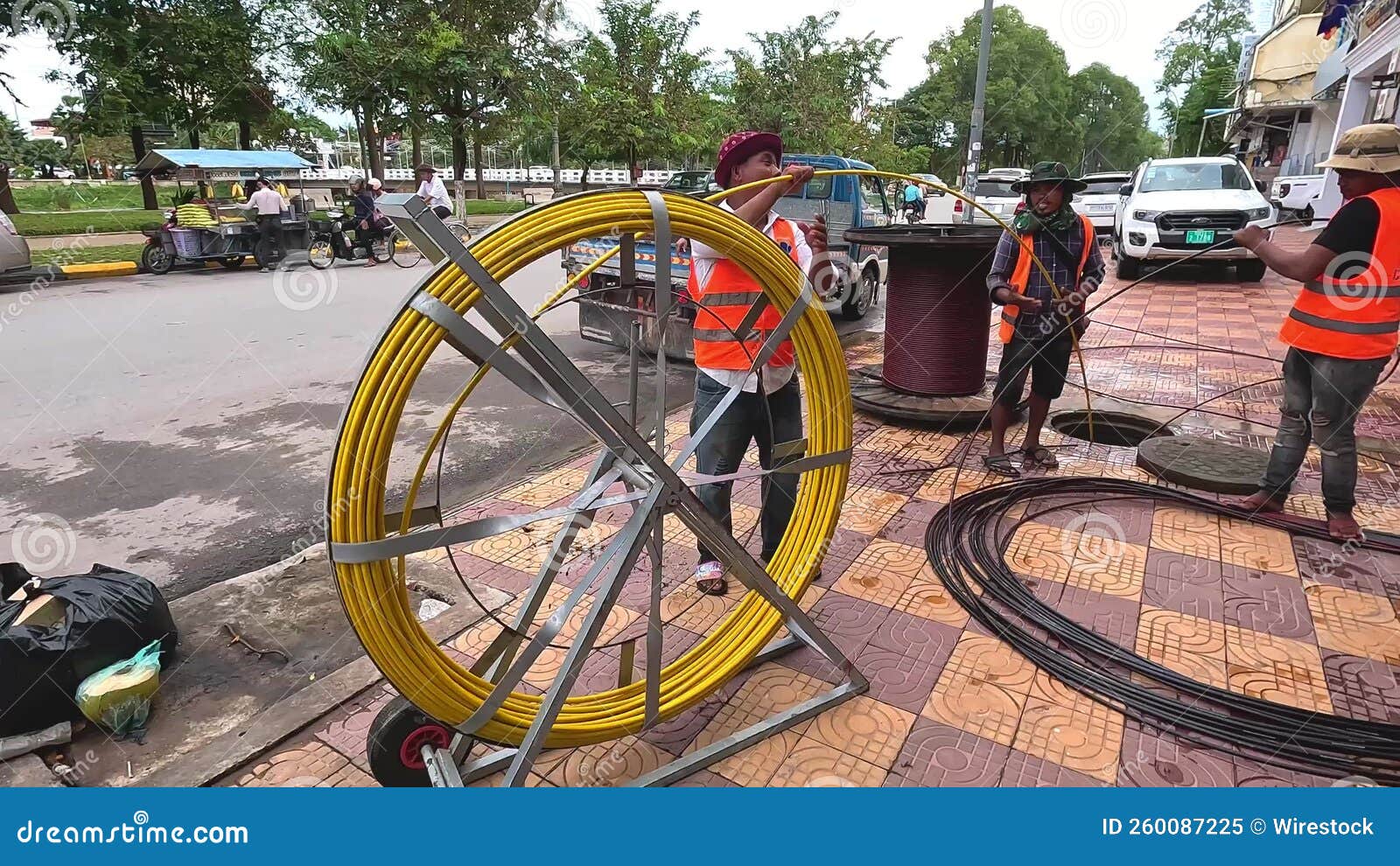 Workers Installing an Internet Cable Under the Ground in the Sidewalk ...