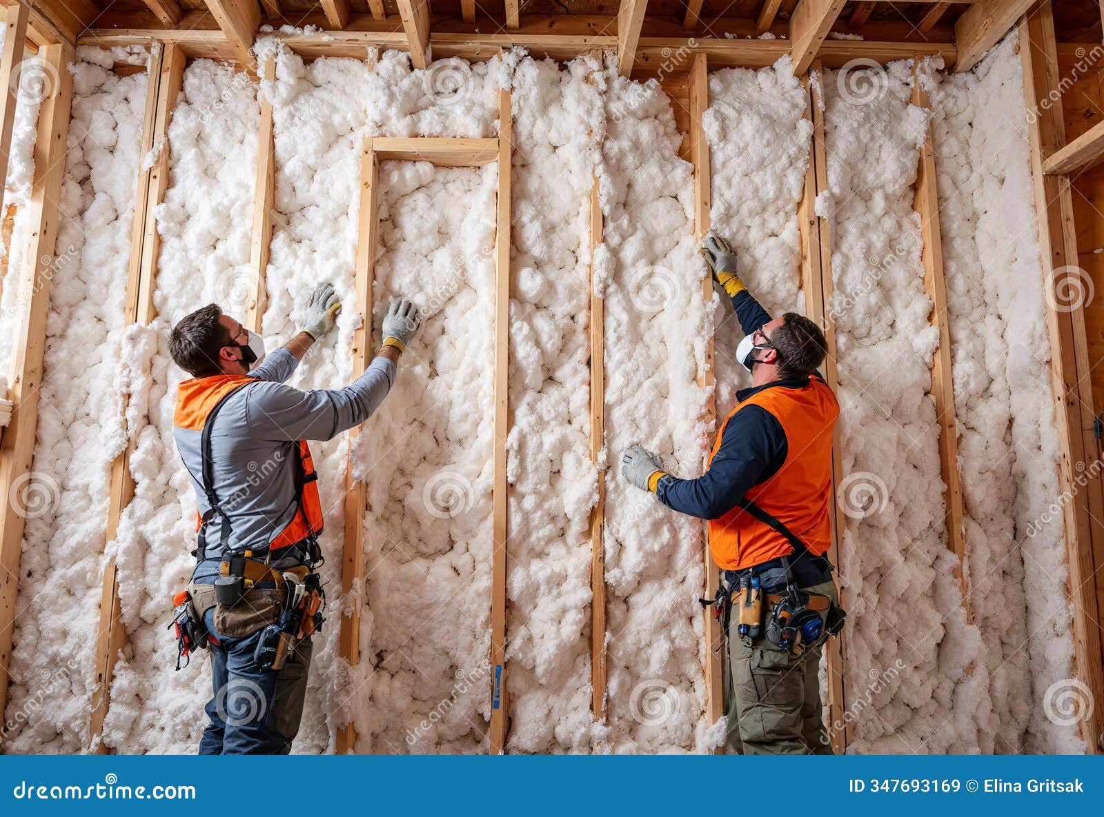 Workers Insulate a Wall with Fiber Material in a Construction Project ...