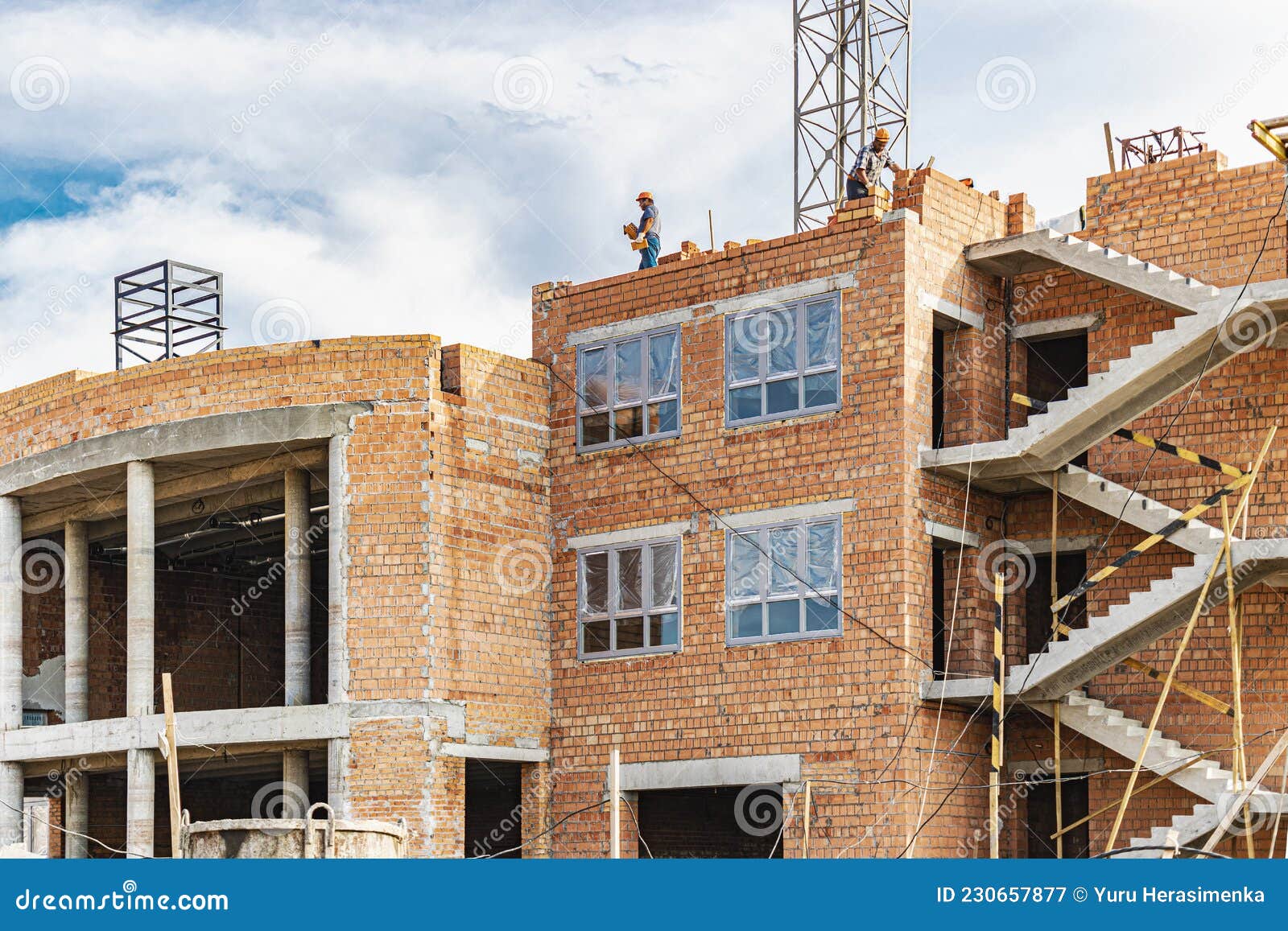 Workers are Laying the Wall of a Building Made of Red Ceramic Bricks ...
