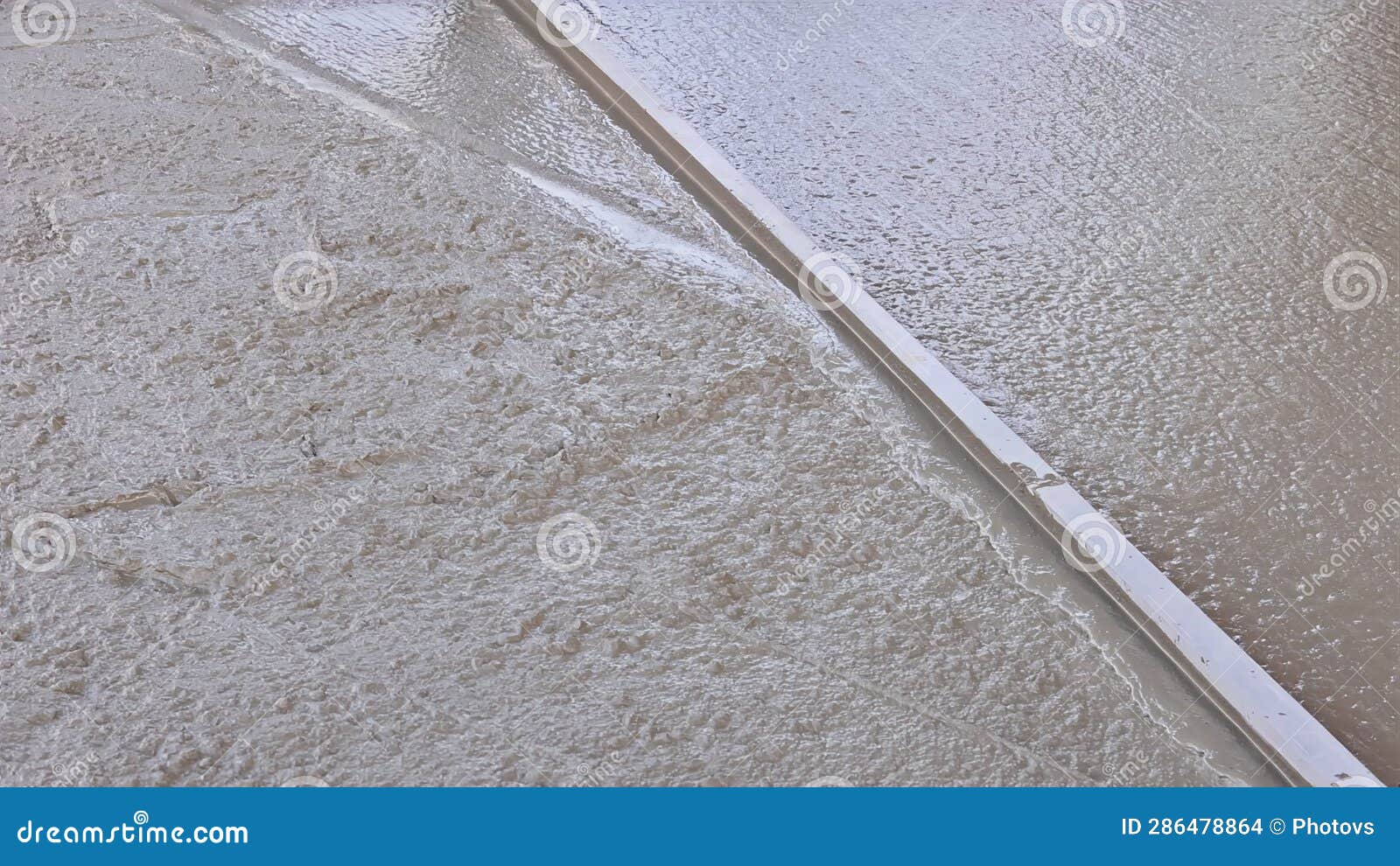 Workers Leveling Concrete for Driveway on Construction Site Using a ...