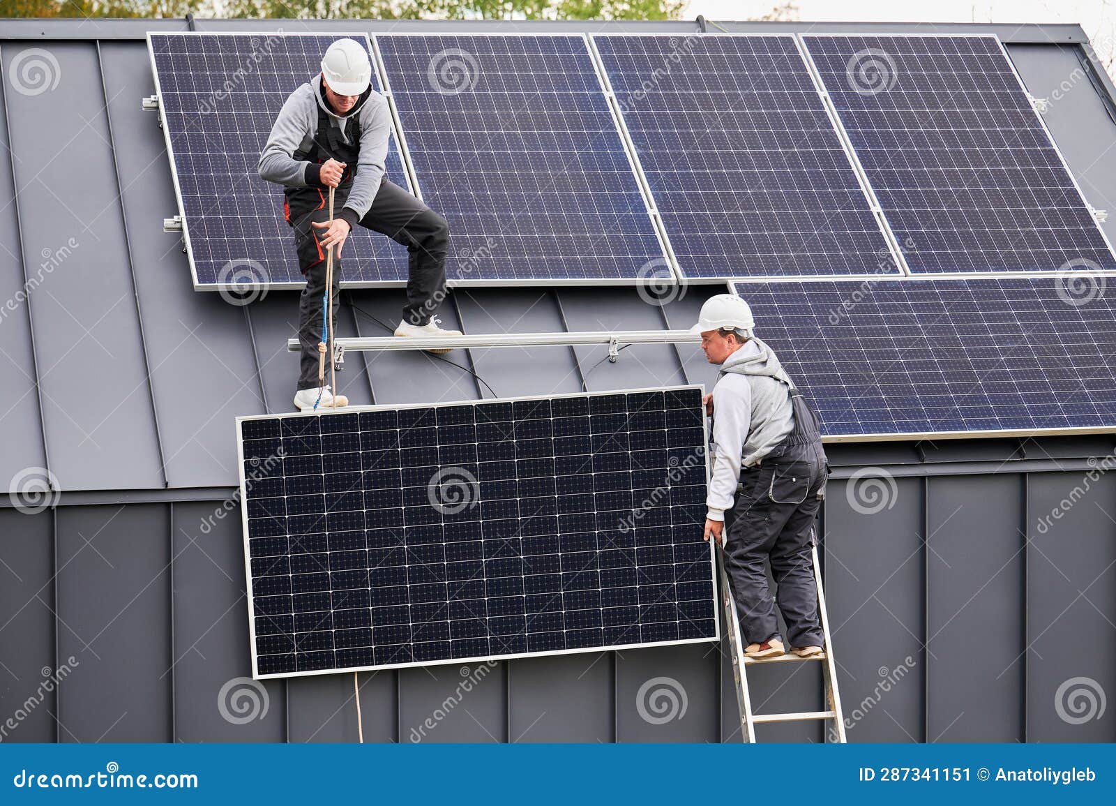 Workers Lifting Up Photovoltaic Solar Module while Installing Solar ...