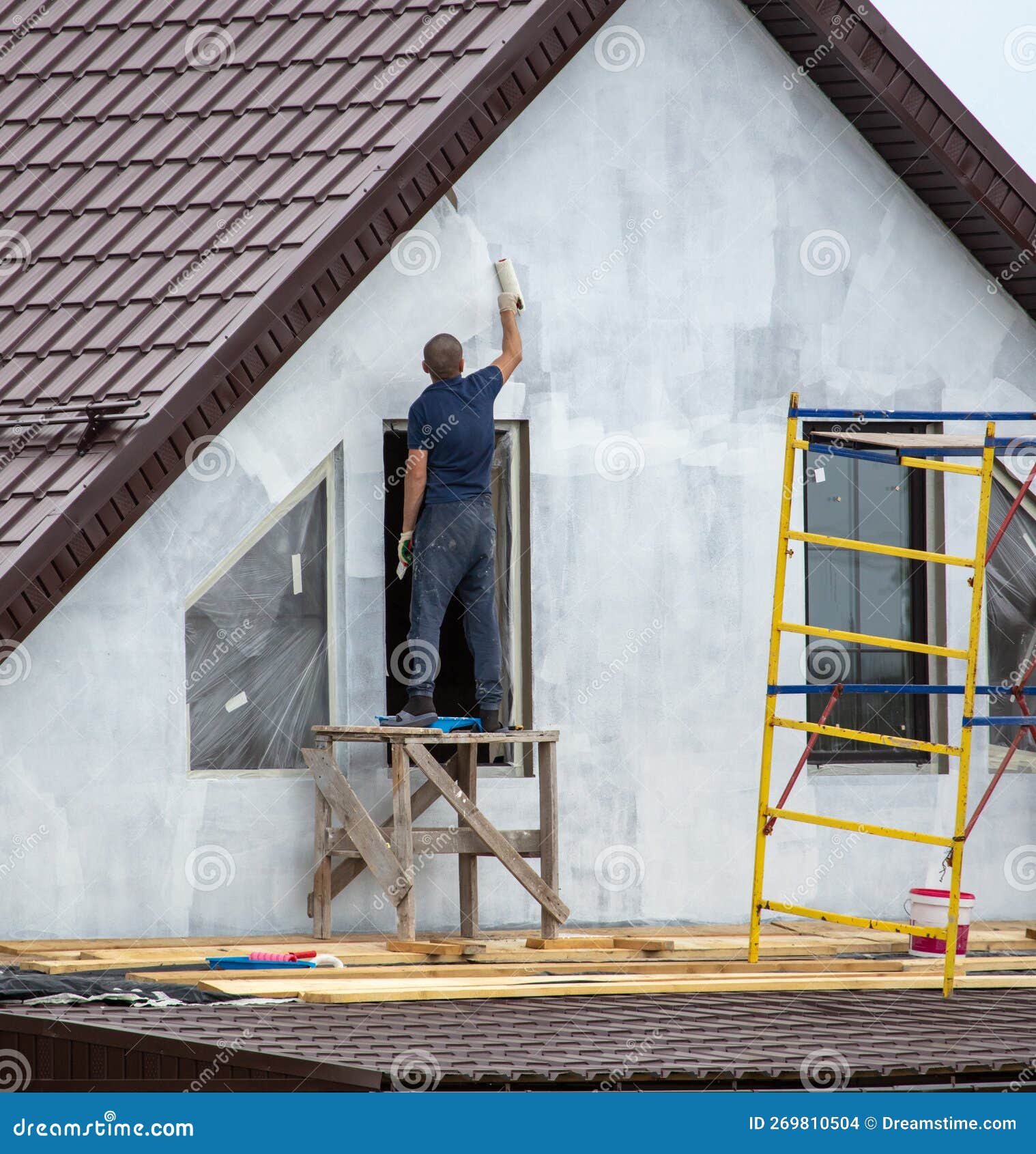 Workers are Priming Outside the Walls of the House. Stock Photo - Image ...