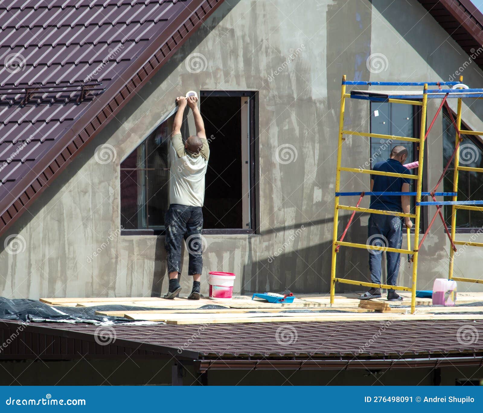 Workers are Priming Outside the Walls of the House. Stock Image - Image ...