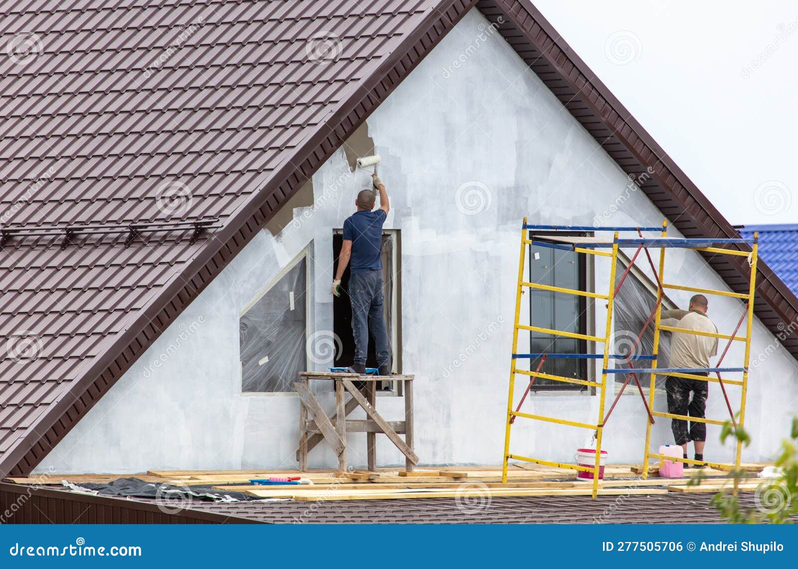 Workers are Priming Outside the Walls of the House. Stock Photo - Image ...
