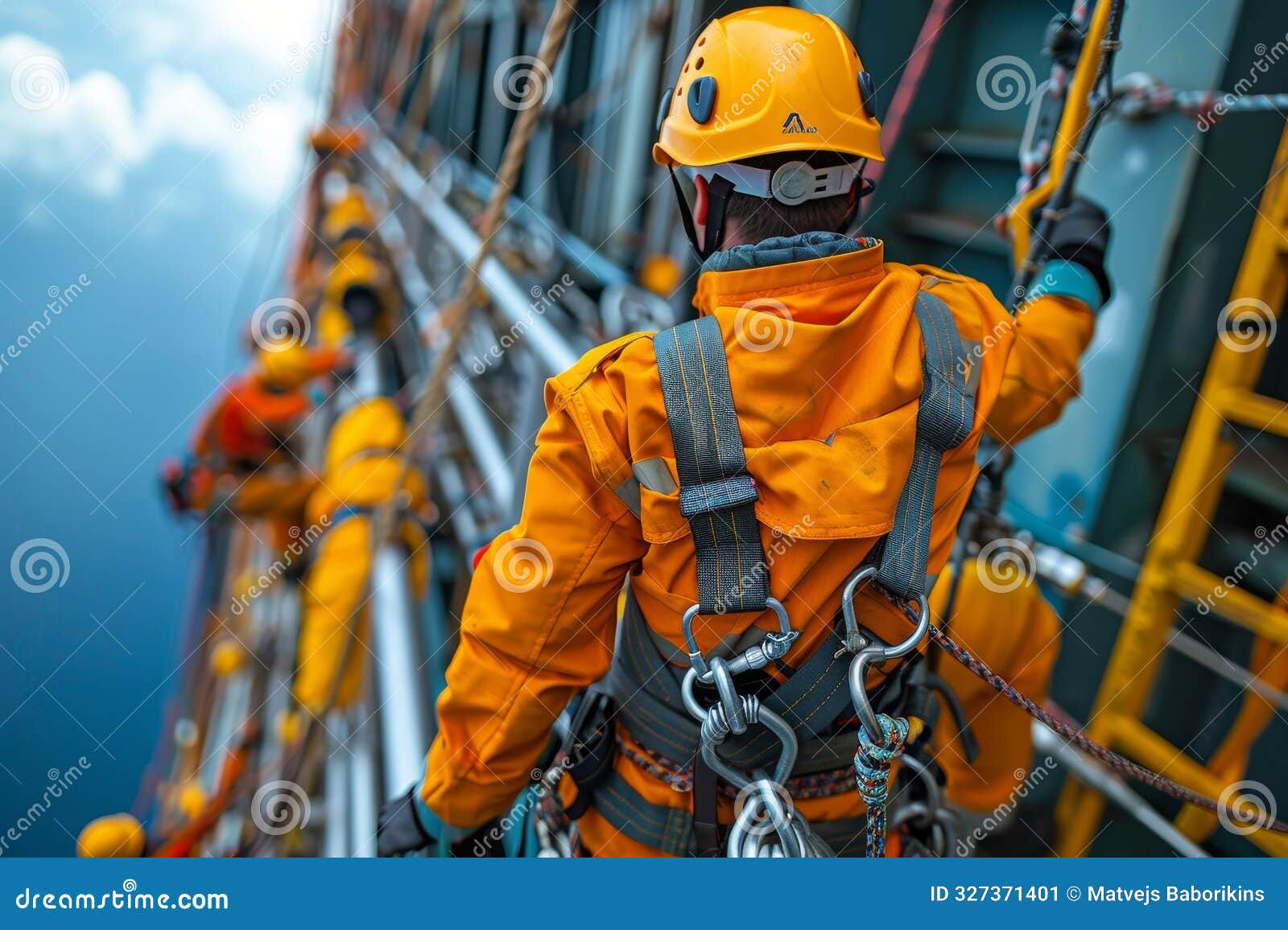 Workers in Safety Harnesses on High Altitude with Blurred Sky ...