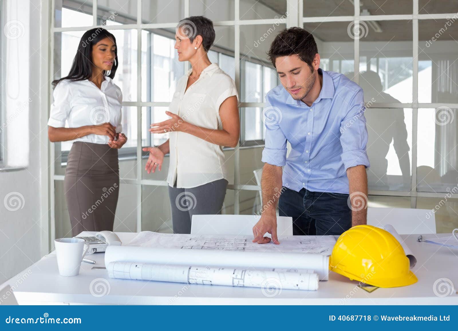 Workers Talking and Looking Over Plans Stock Photo - Image of ...