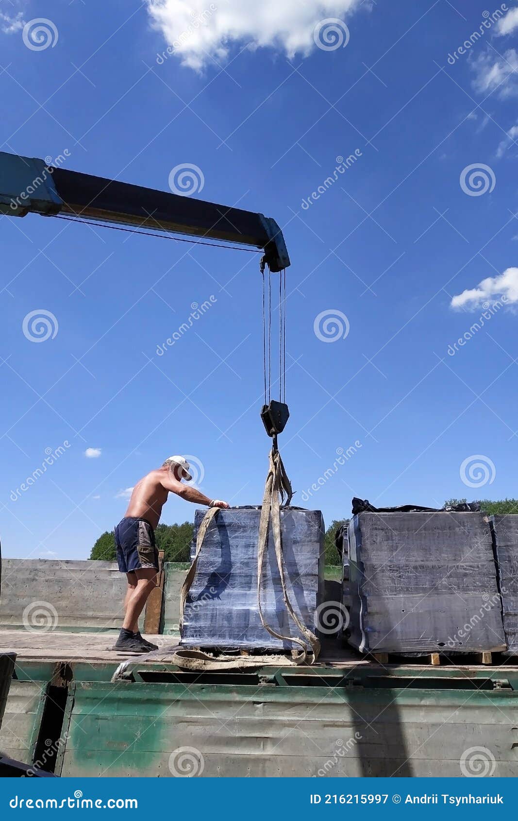 Workers Unload Pallets with Bricks by Means of the Crane of Automobile ...