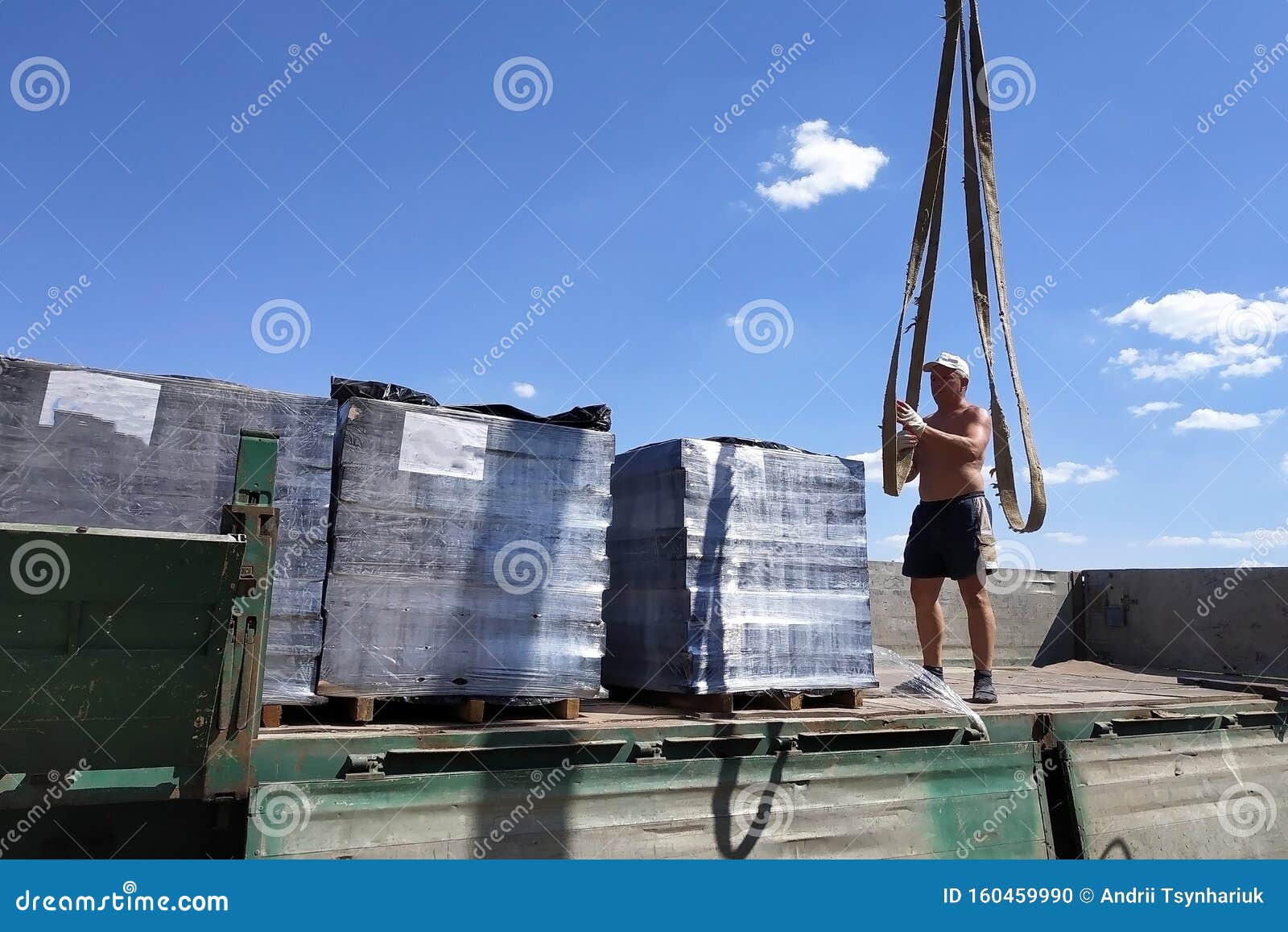 Workers Unload Pallets with Bricks by Means of the Crane of Automobile ...