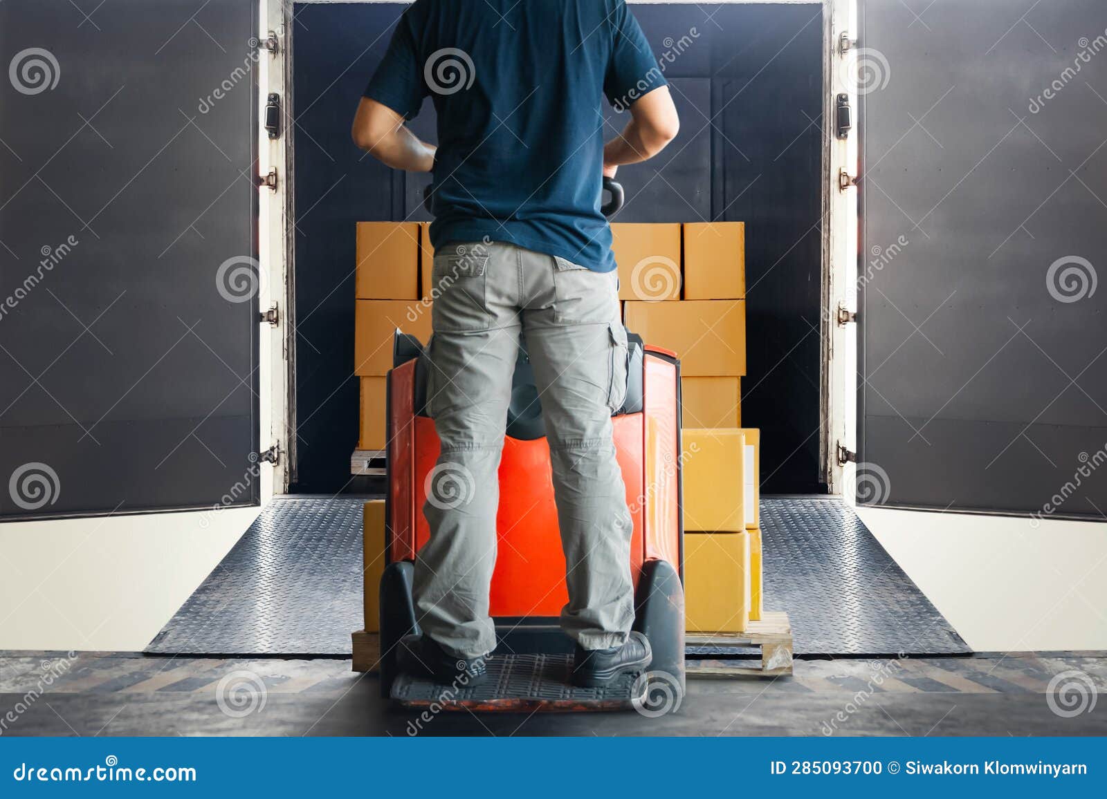 Workers Unloading Package Boxes into Container. Trucks Loading Dock ...