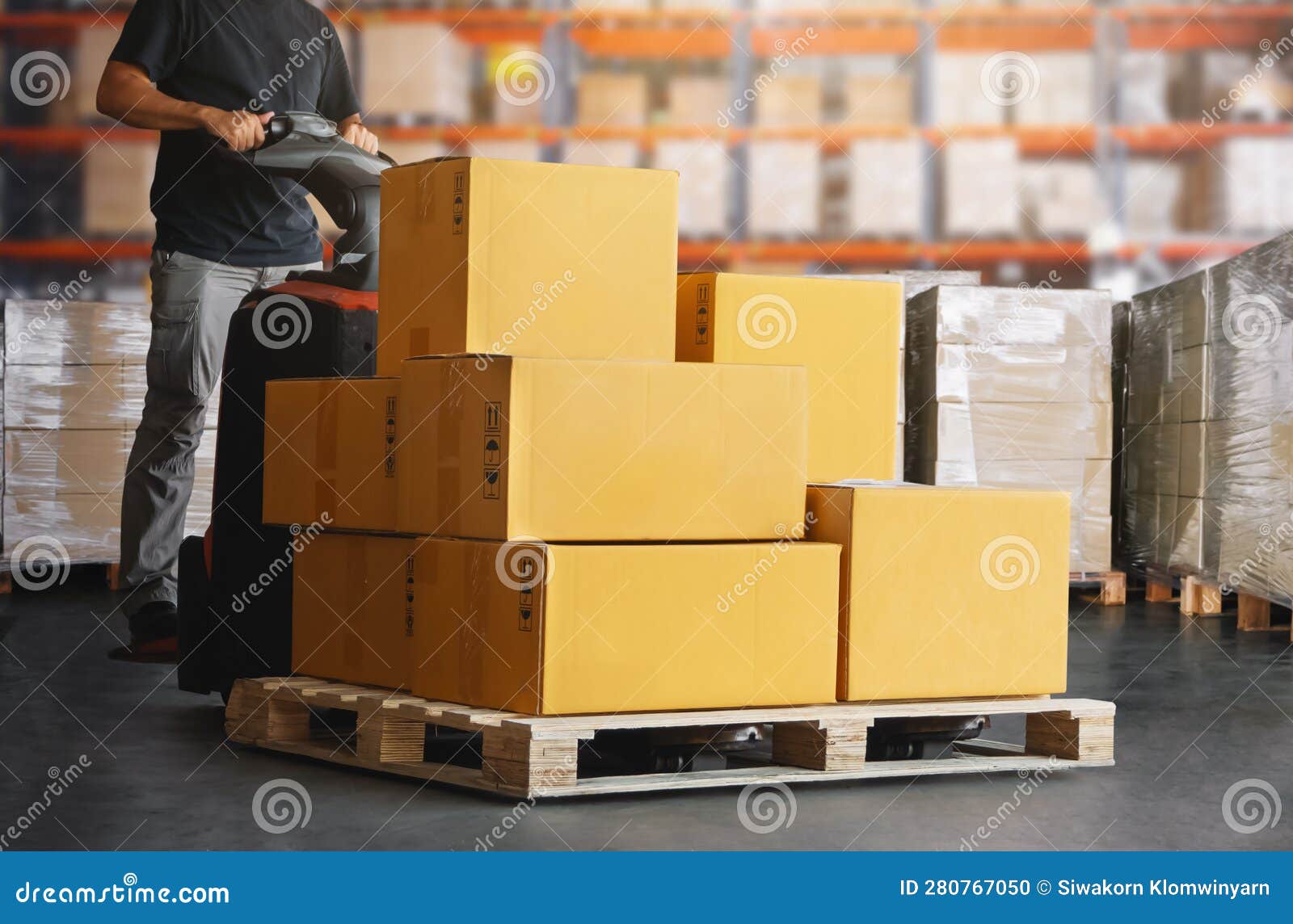 Workers Unloading Package Boxes on Pallets in Warehouse. Electric ...