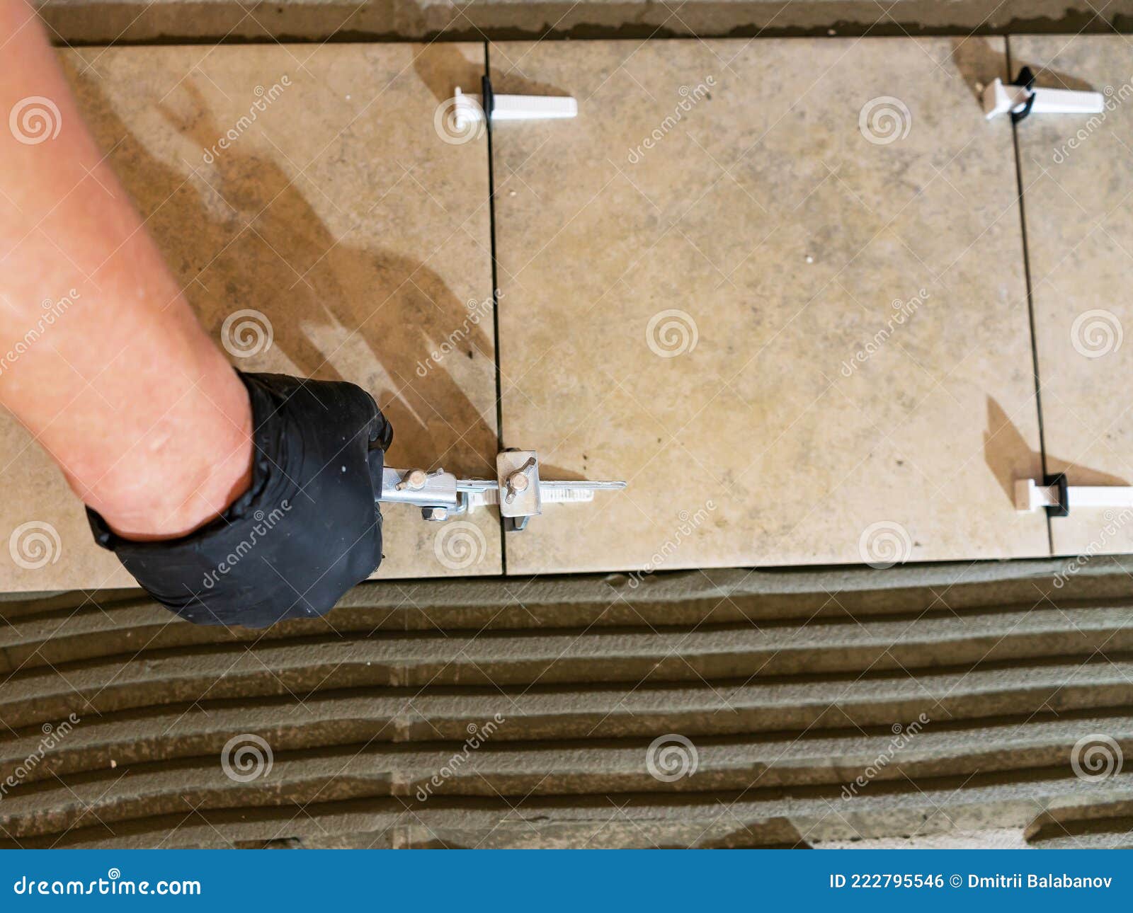 Workers are Using Plastic Clamps and Wedges To Leveling the Ceramic ...