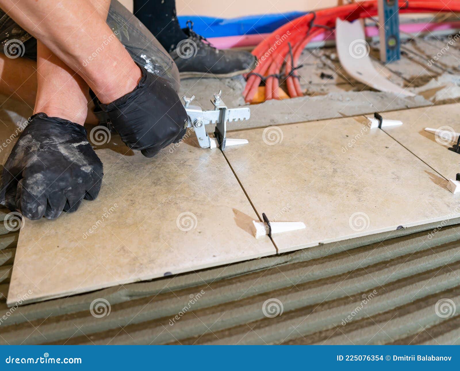 Workers are Using Plastic Clamps and Wedges To Leveling the Ceramic ...