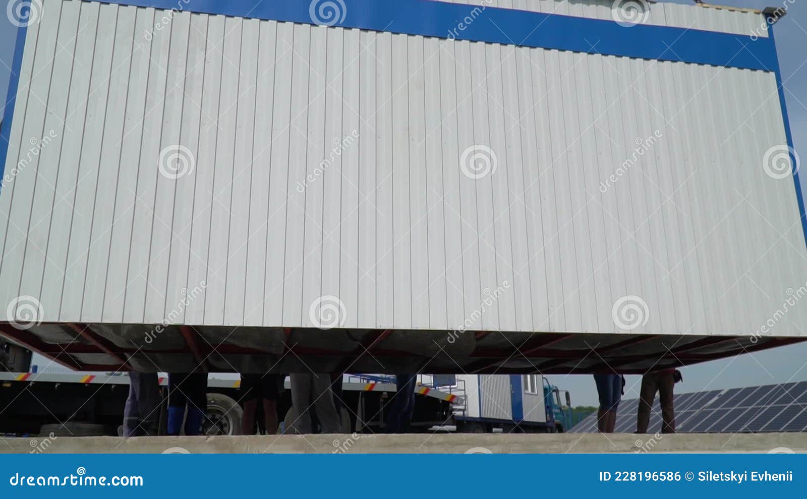 Workers are Walking Behind a Massive Transformer Lowered on a Crane ...
