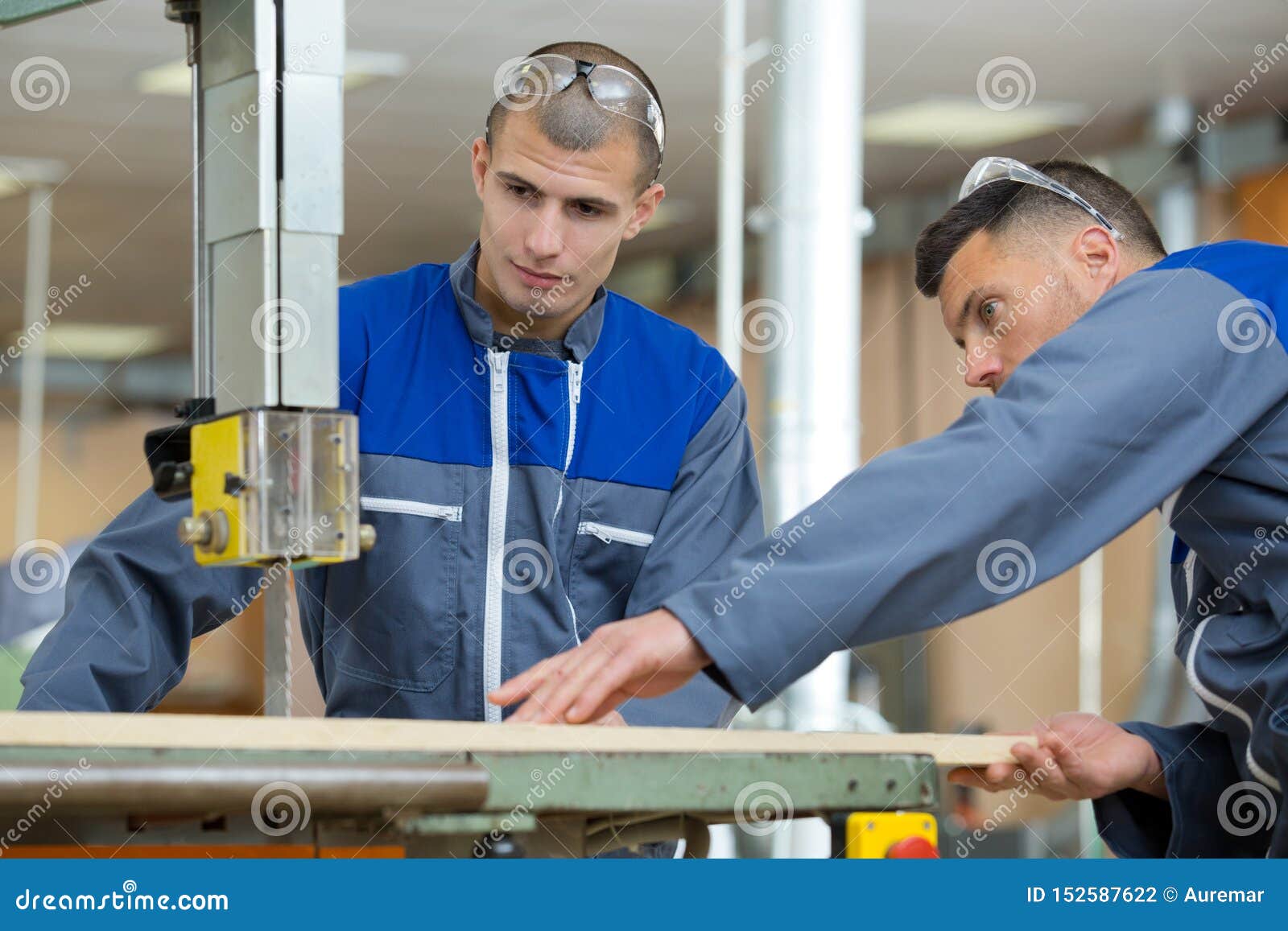 Workers Wearing Earmuffs Using Saw Stock Photo - Image of looking ...