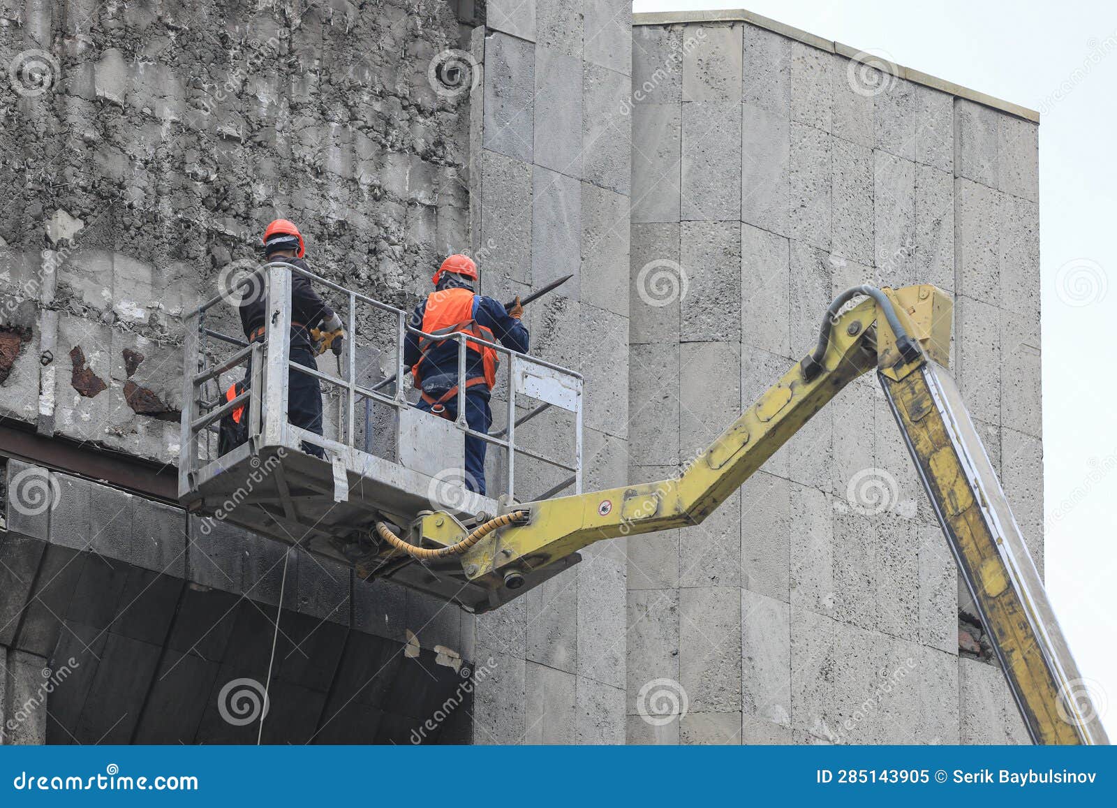 Workers Work on Construction Hoist on the Wall of a Building Stock ...